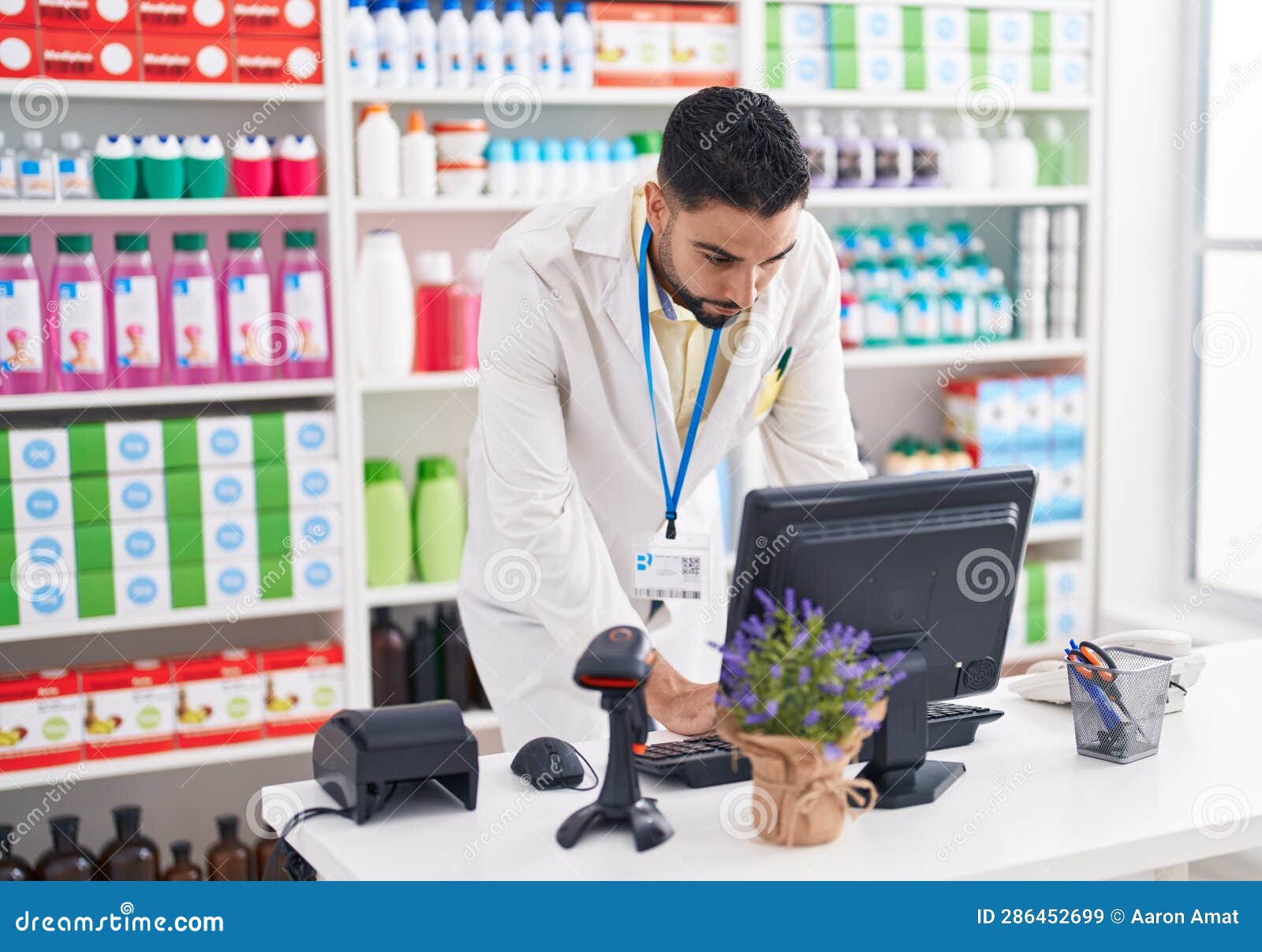 Young Arab Man Pharmacist Using Computer at Pharmacy Stock Image ...
