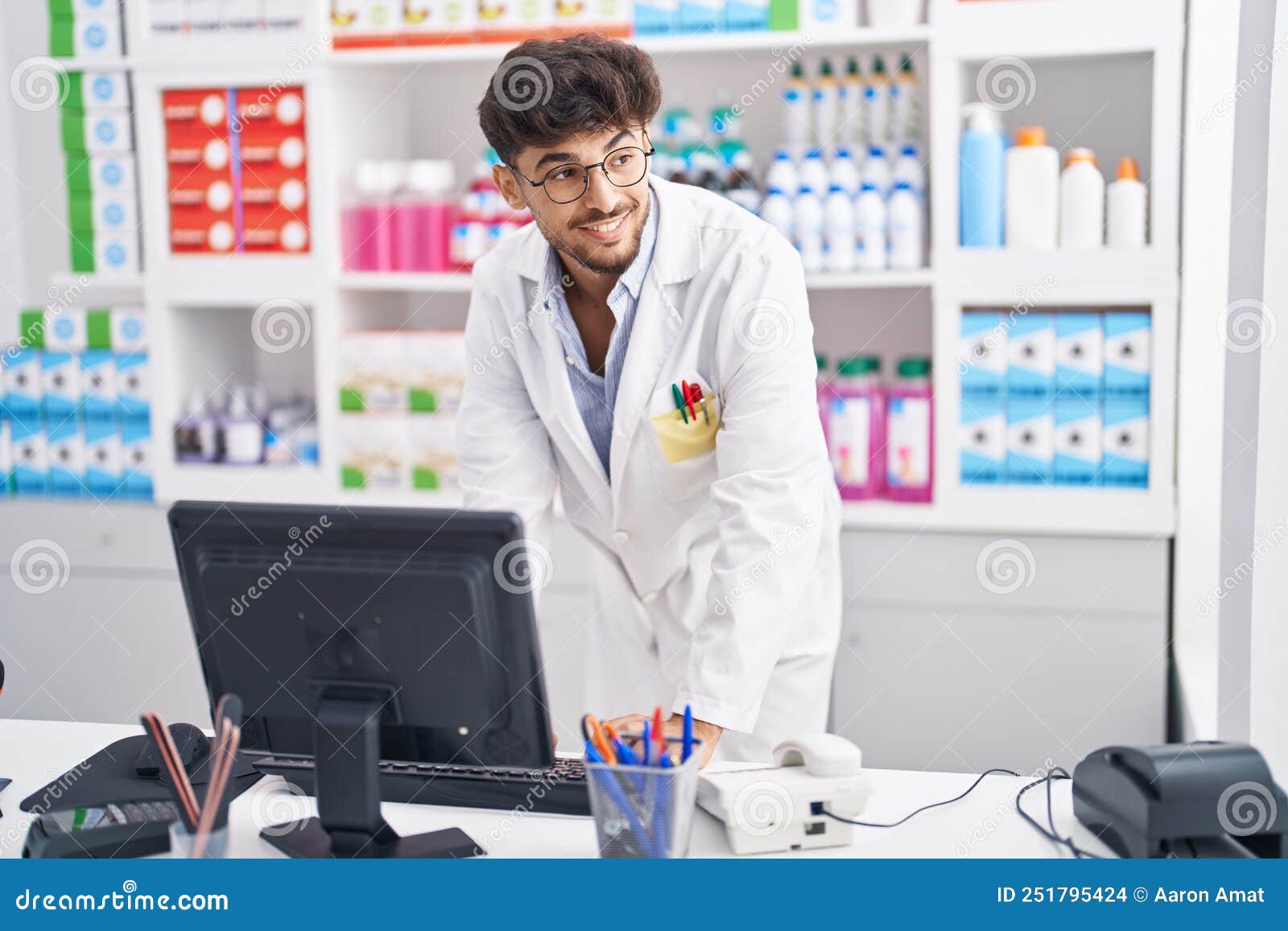 Young Arab Man Pharmacist Using Computer Working at Pharmacy Stock ...