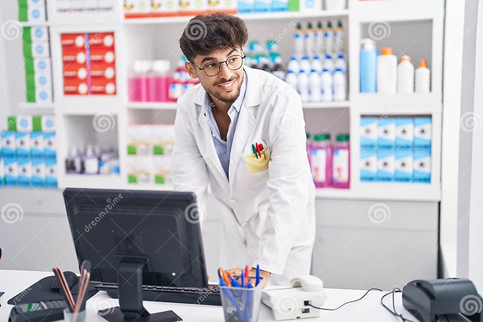 Young Arab Man Pharmacist Using Computer Working at Pharmacy Stock ...
