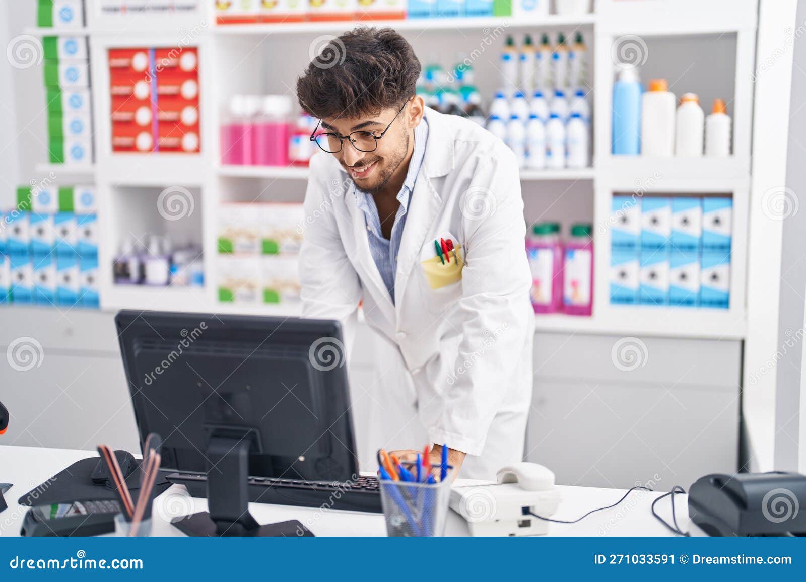Young Arab Man Pharmacist Using Computer Working at Pharmacy Stock ...
