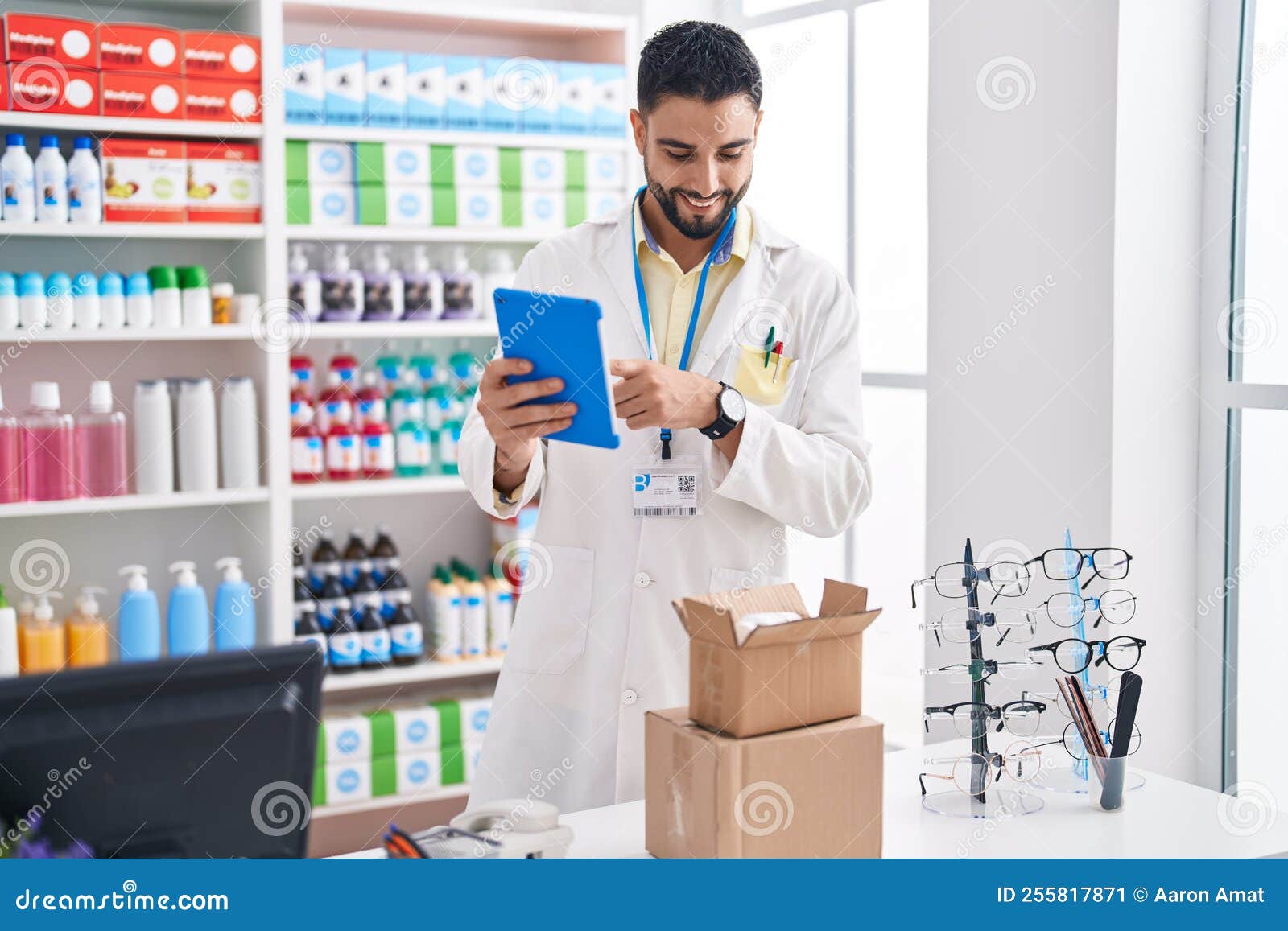 Young Arab Man Pharmacist Using Touchpad Holding Pills Bottle at ...