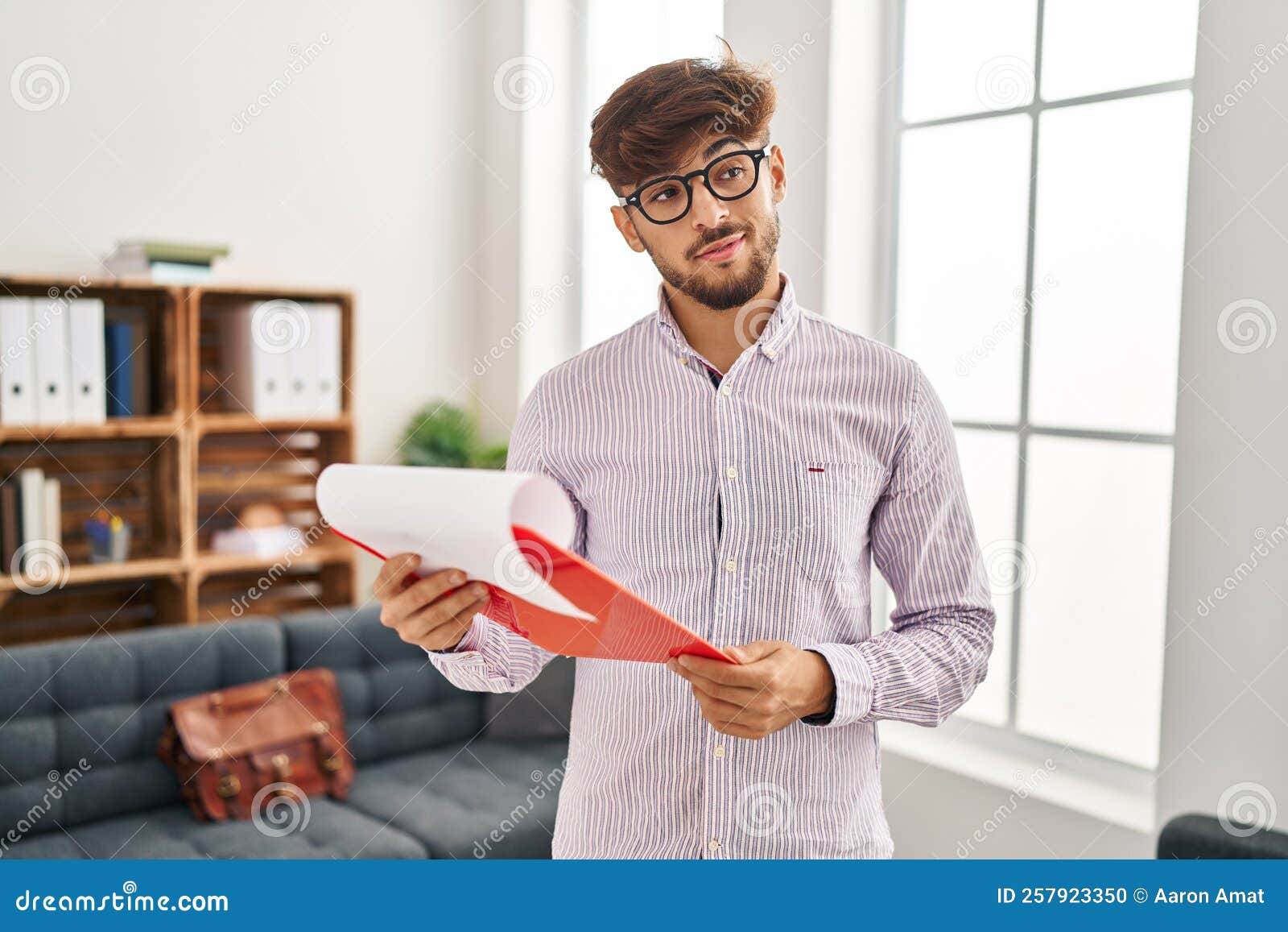 Young Arab Man Psychologist Reading Document at Psychology Center Stock ...