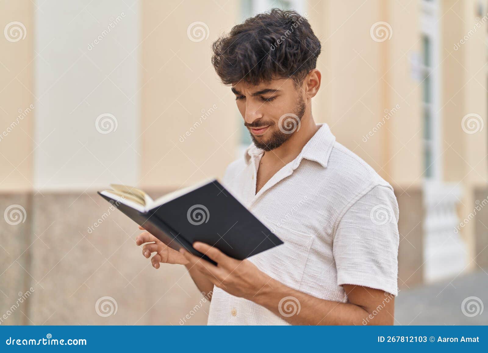 Young Arab Man Reading Book at Street Stock Image - Image of serious ...