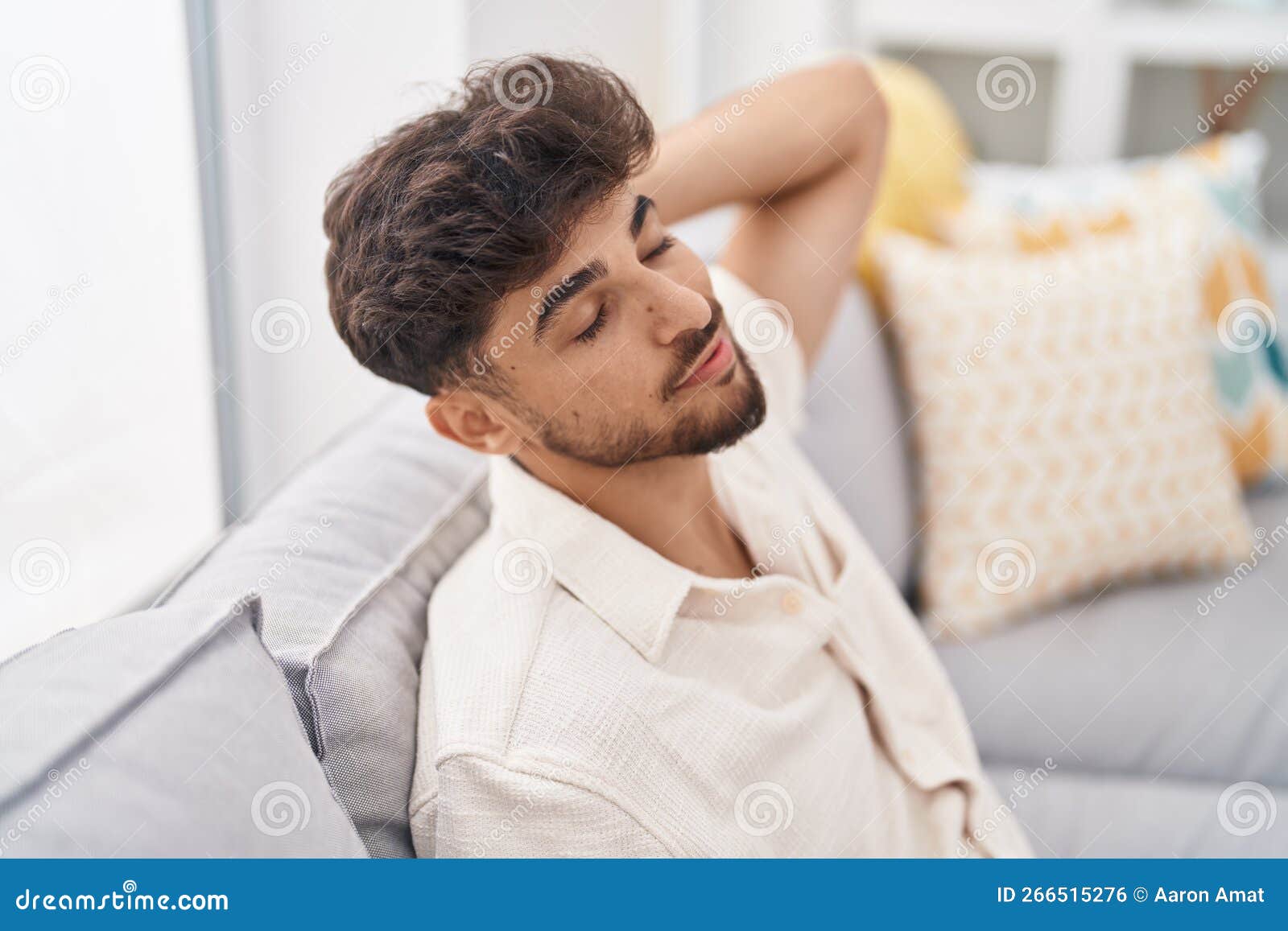 Young Arab Man Relaxed with Hand on Head Sitting on Sofa at Home Stock ...
