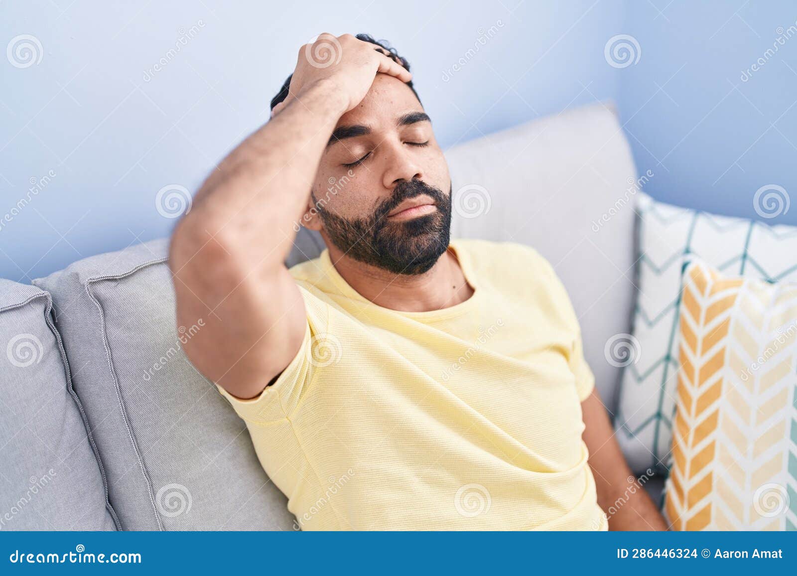 Young Arab Man Relaxed with Hand on Head Sitting on Sofa at Home Stock ...