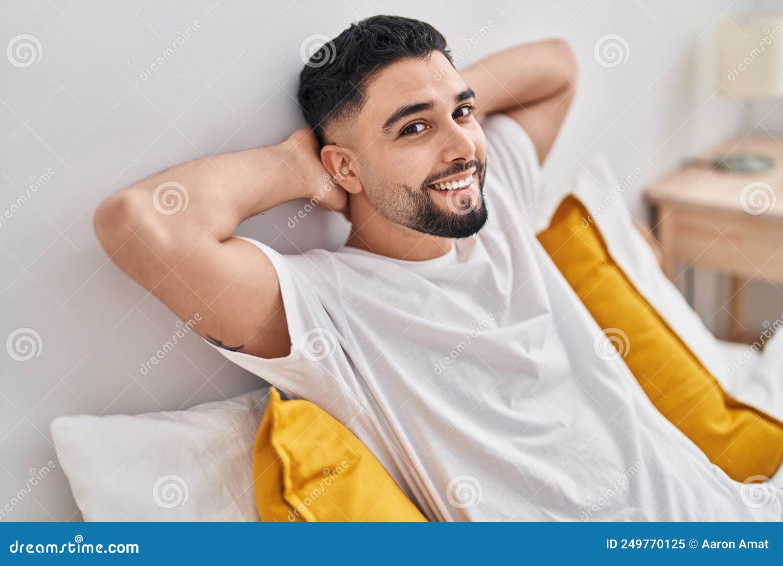 Young Arab Man Relaxed with Hands on Head Sitting on Bed at Bedroom ...