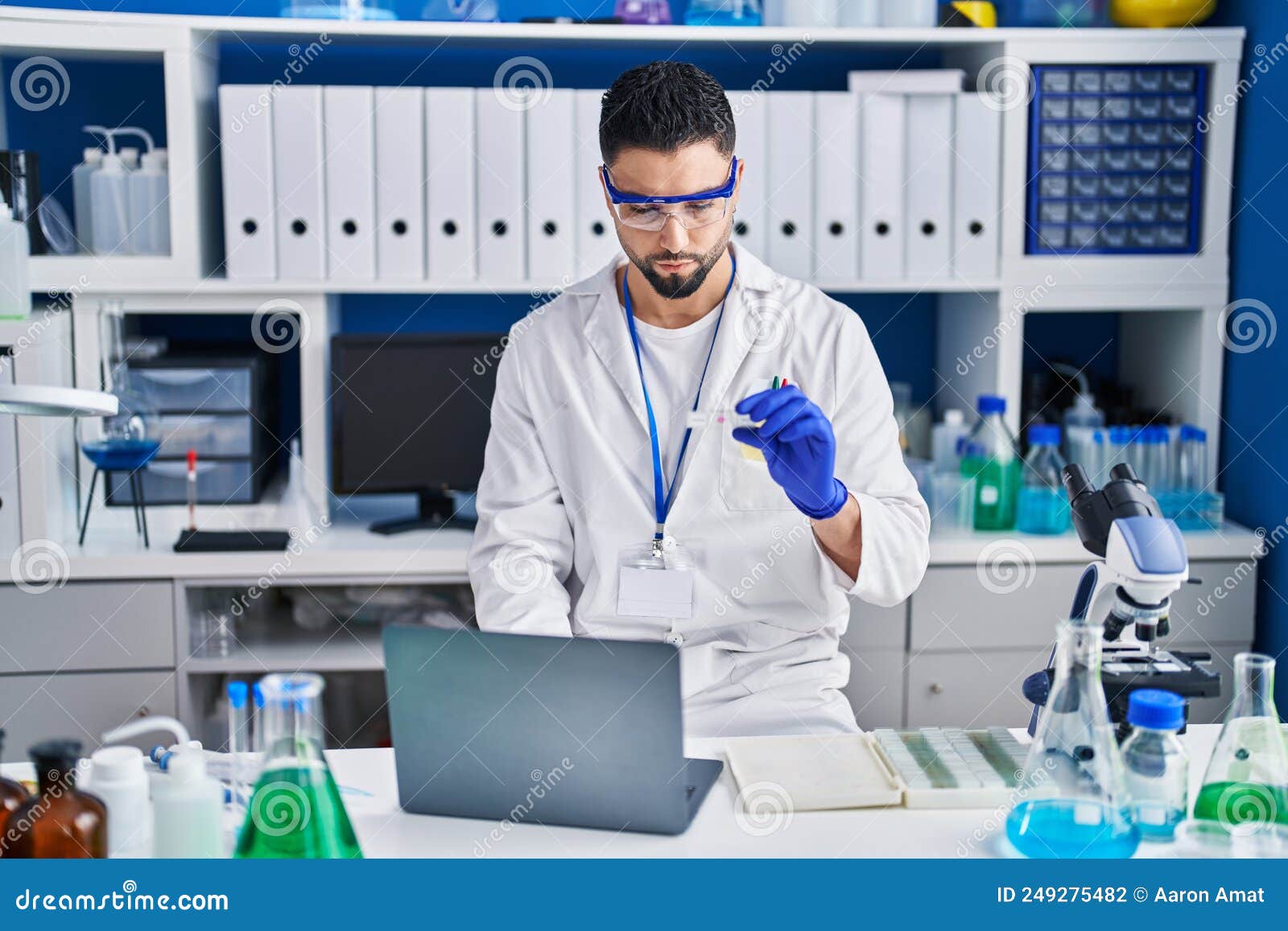 Young Arab Man Scientist Using Laptop Holding Sample at Laboratory ...