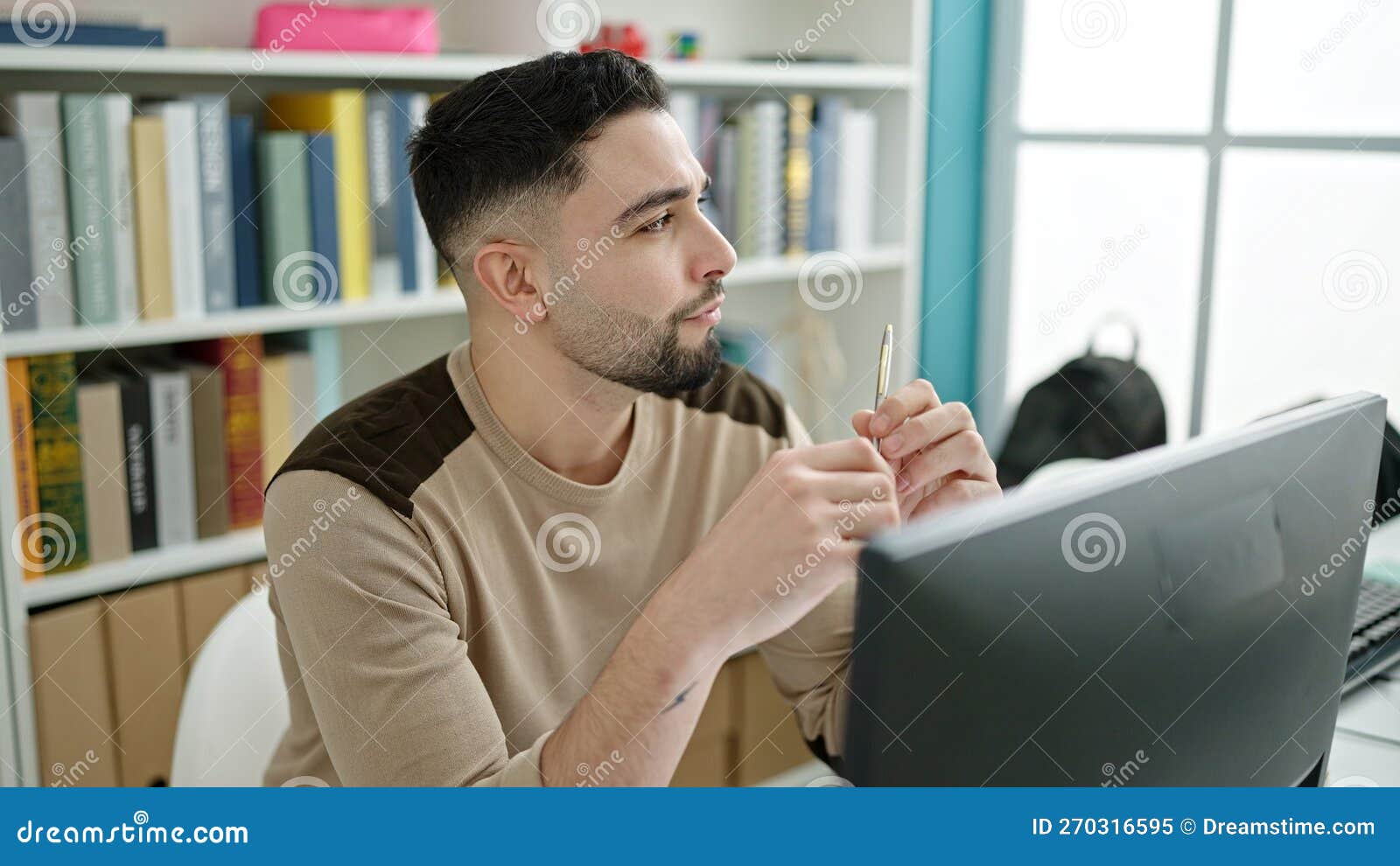 Young Arab Man Student Using Computer Studying with Doubt Expression at ...