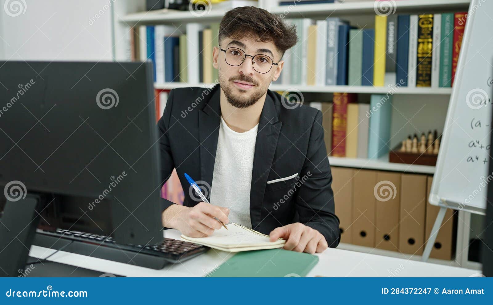 Young Arab Man Student Using Computer Writing on Notebook at University ...