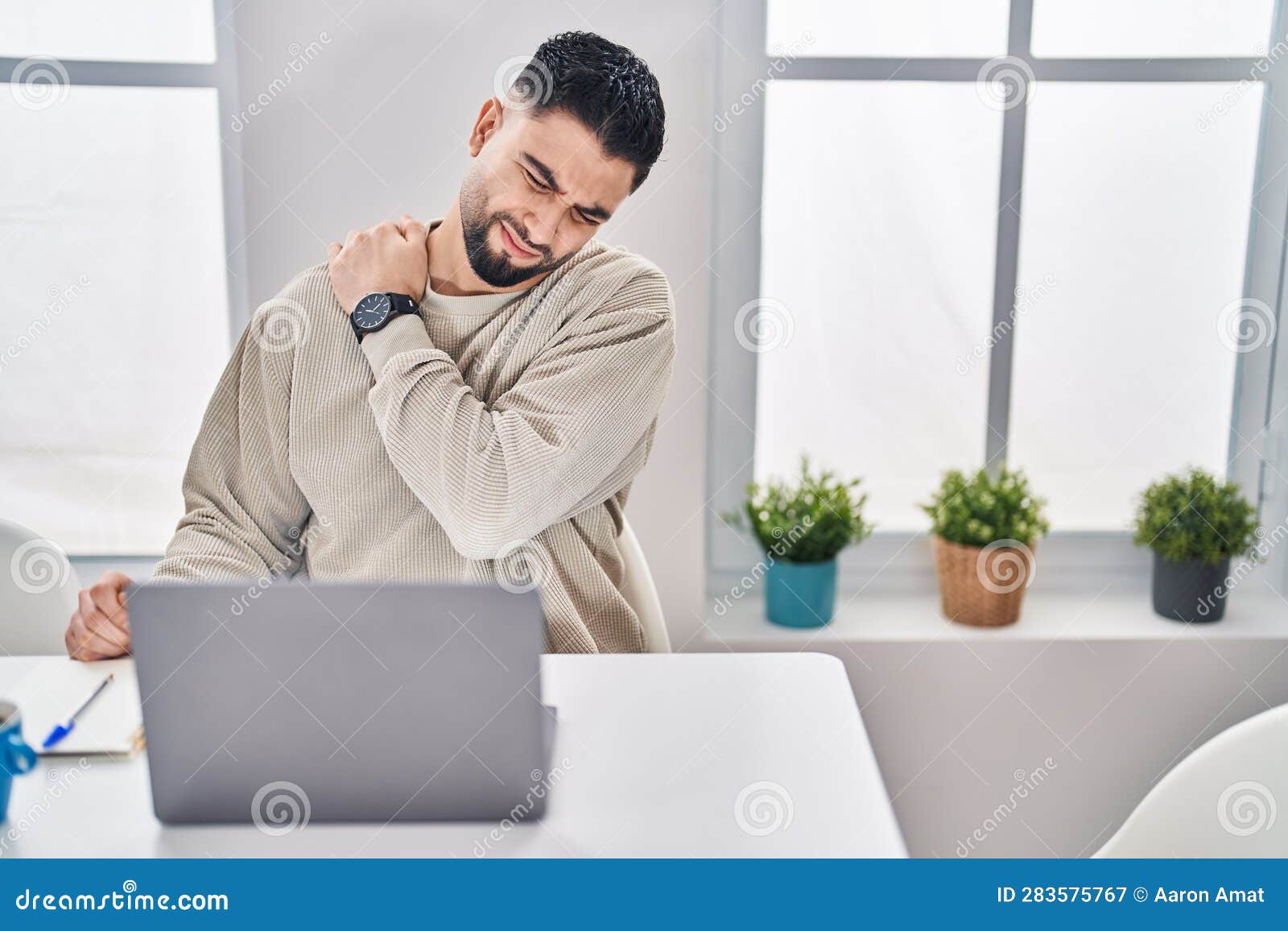 Young Arab Man Suffering for Back Ache Sitting on Table Working at Home ...