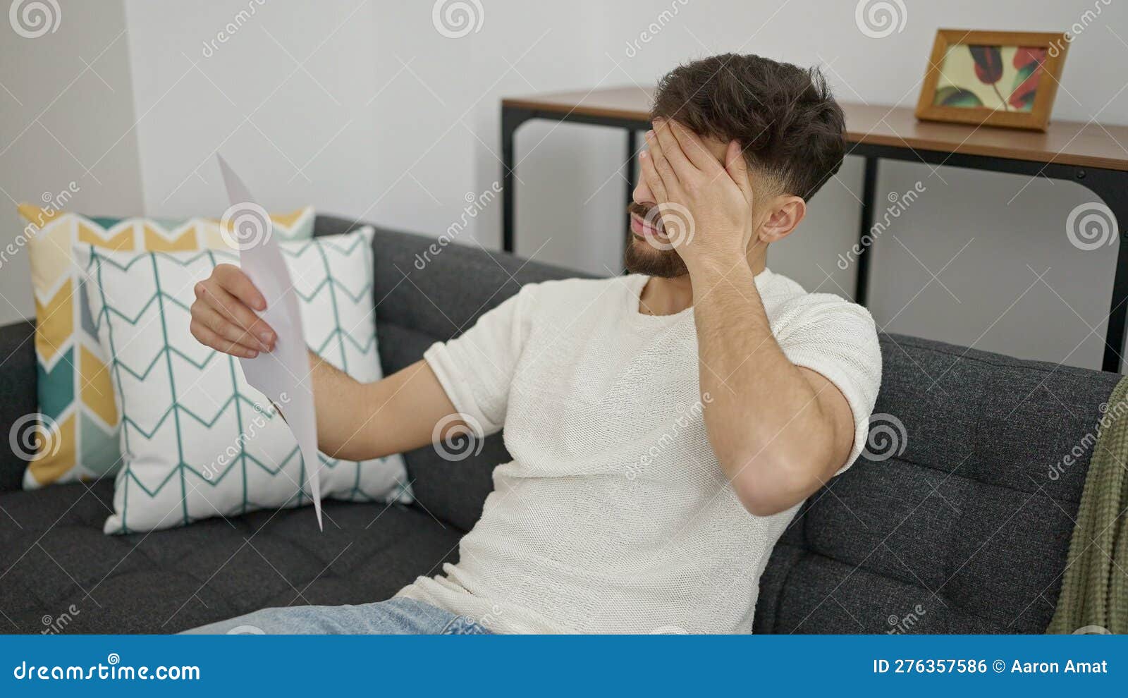 Young Arab Man Using Paper As a Hand Fan for Hot at Home Stock Photo ...