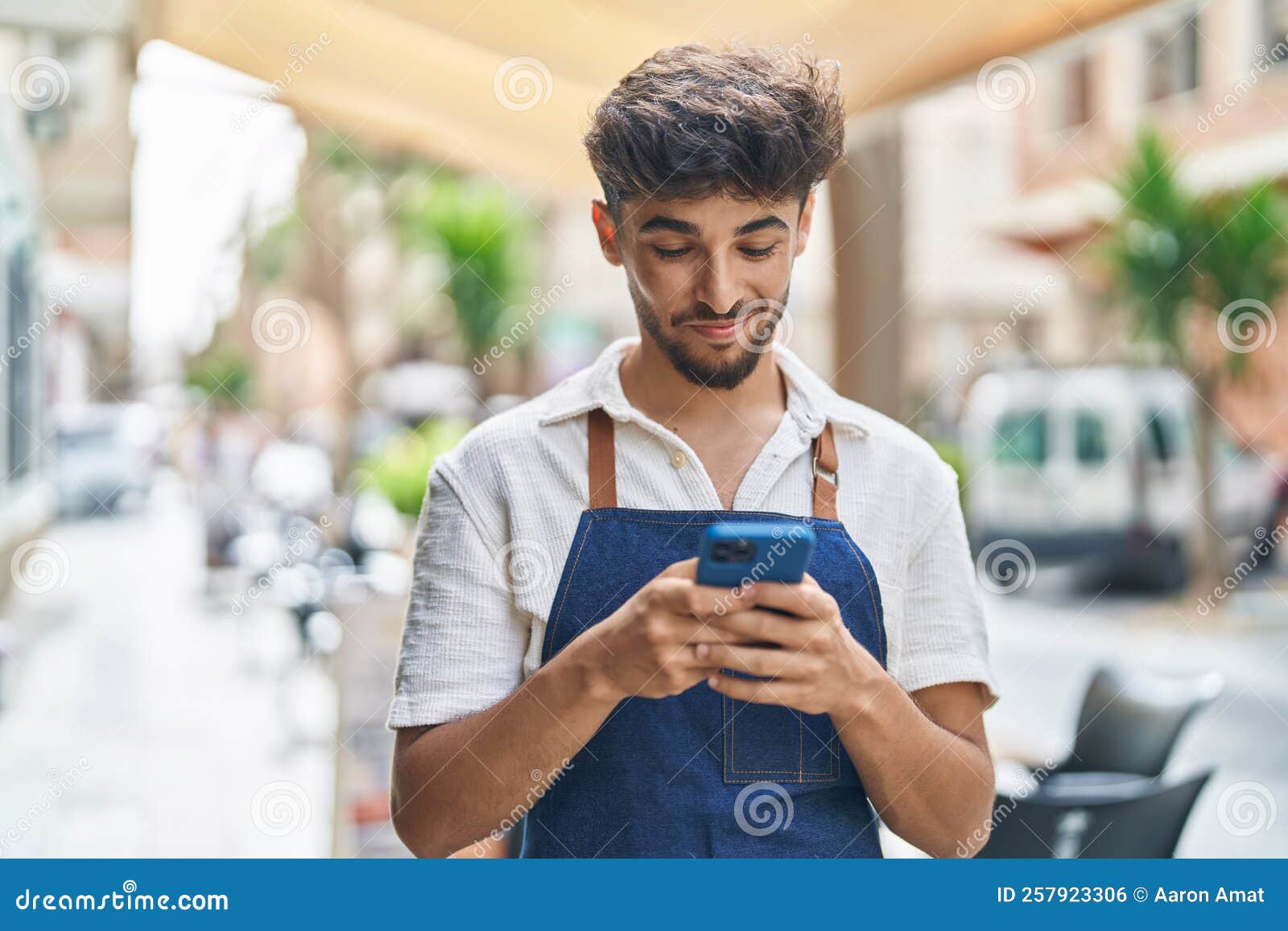 Young Arab Man Waiter Using Smartphone Working at Restaurant Stock ...