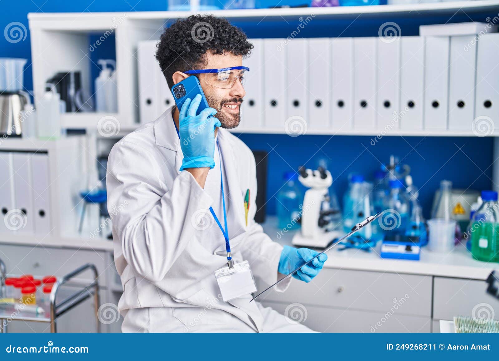 Young Arab Man Wearing Scientist Uniform Talking on the Smartphone at ...