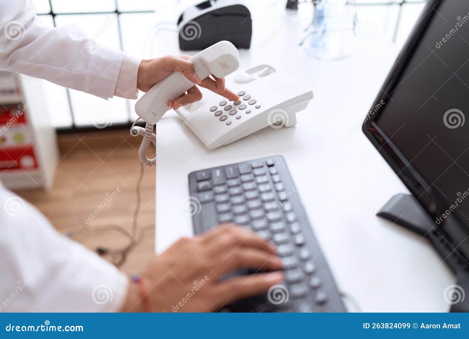Young Arab Woman Pharmacist Using Telephone and Computer at Pharmacy ...