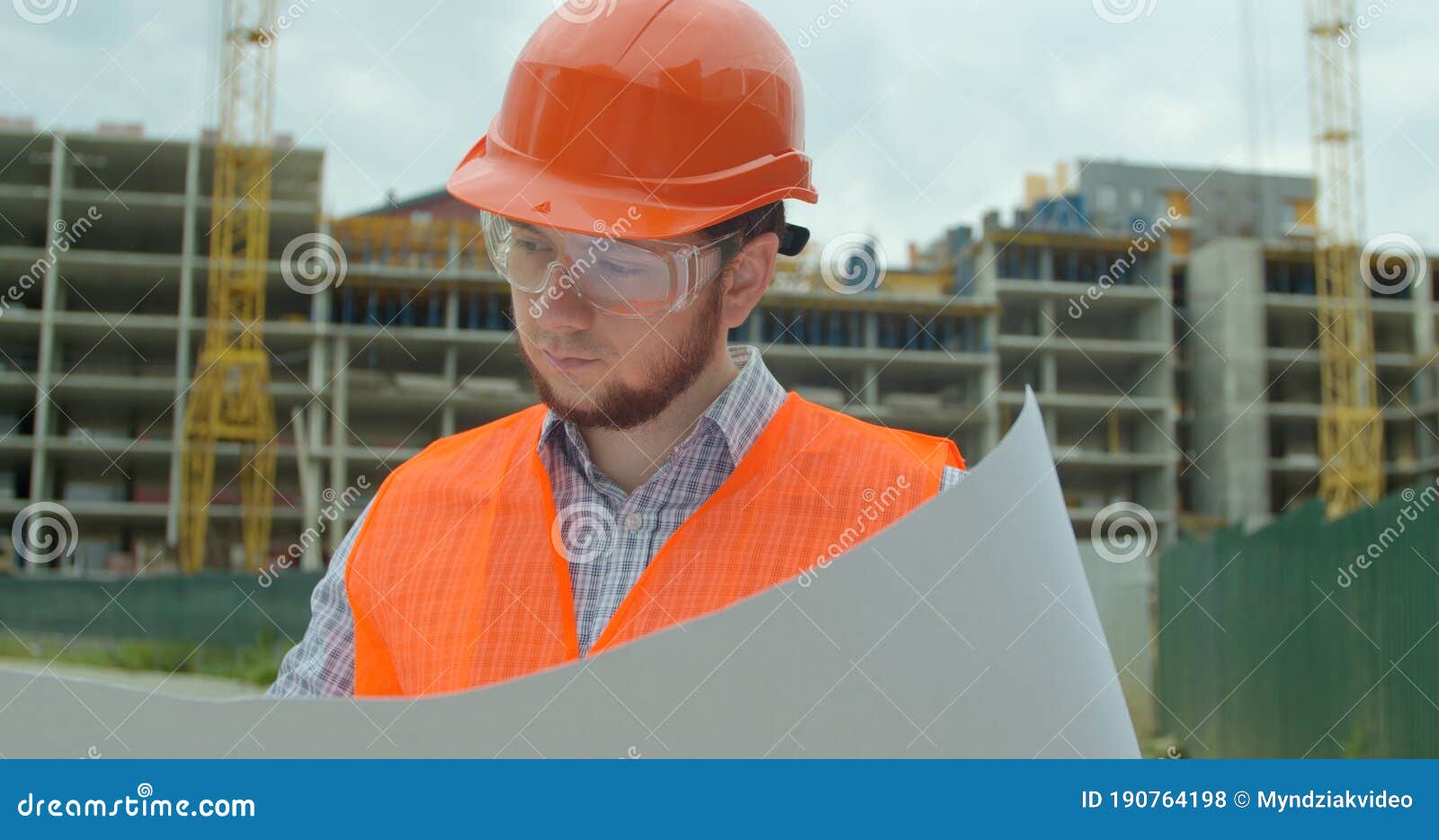 Young Architect or Builder with Hard Hat Holding Blueprint in His Hands ...