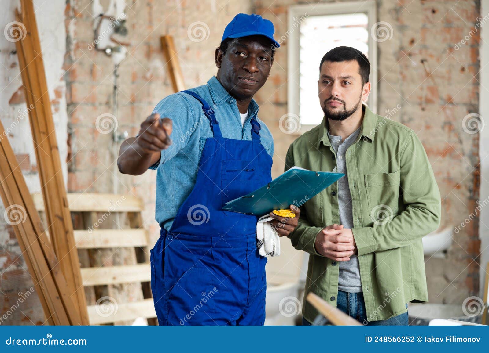 Two Men Talking on Indoor Construction Site Stock Photo - Image of ...
