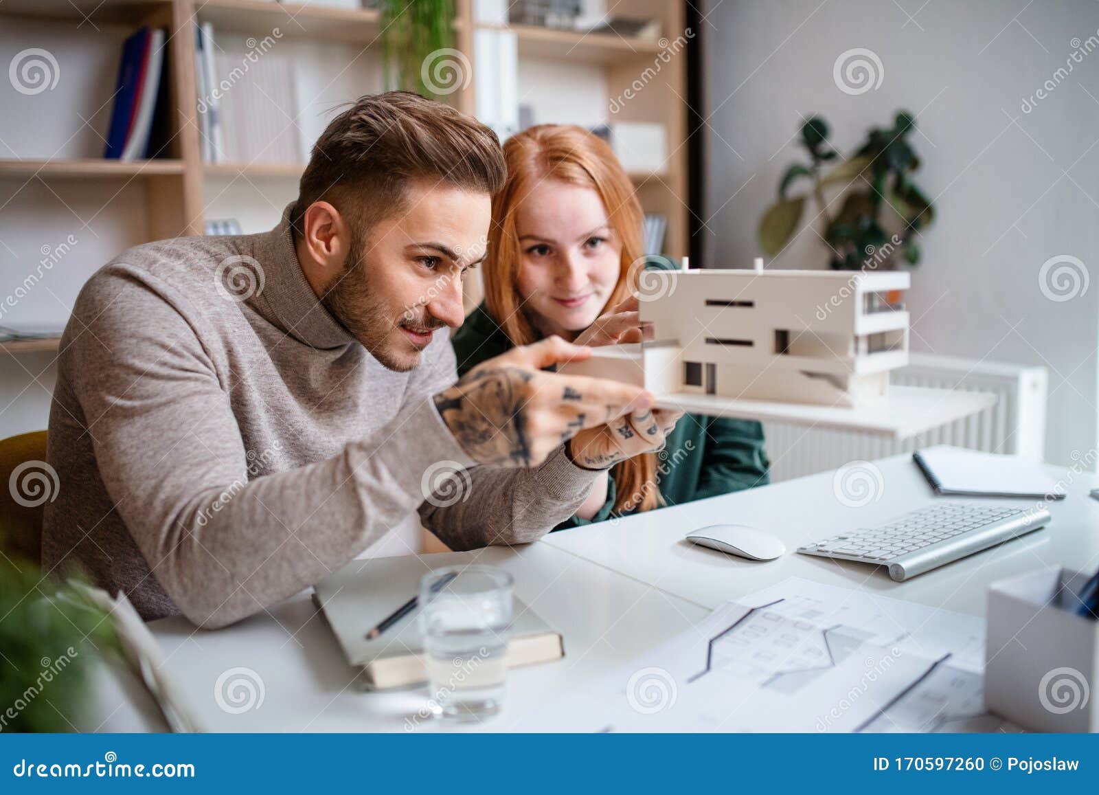 Architects with Model of House Sitting at the Desk Indoors in Office ...