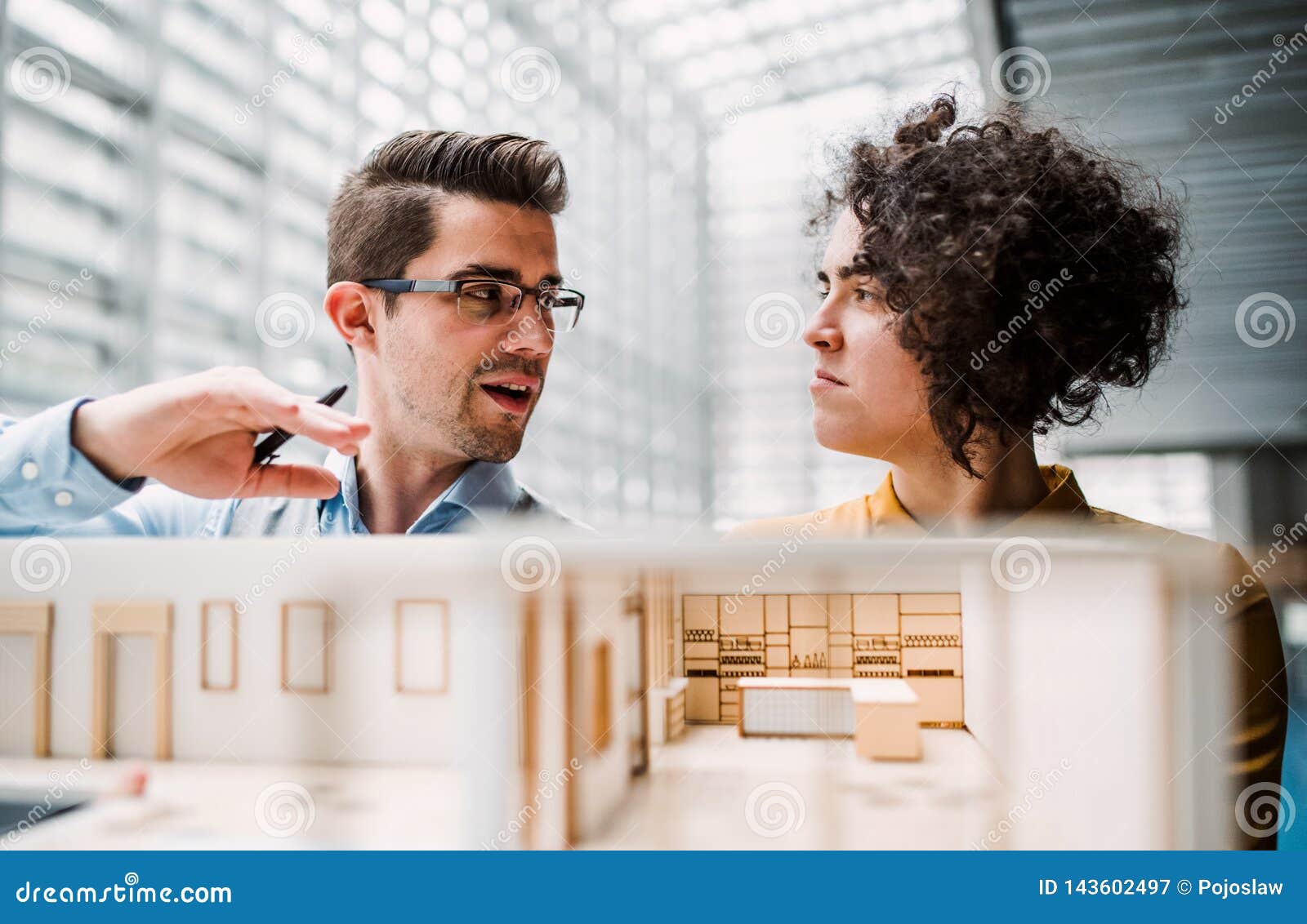 Young Architects with Model of a House Standing in Office, Talking ...