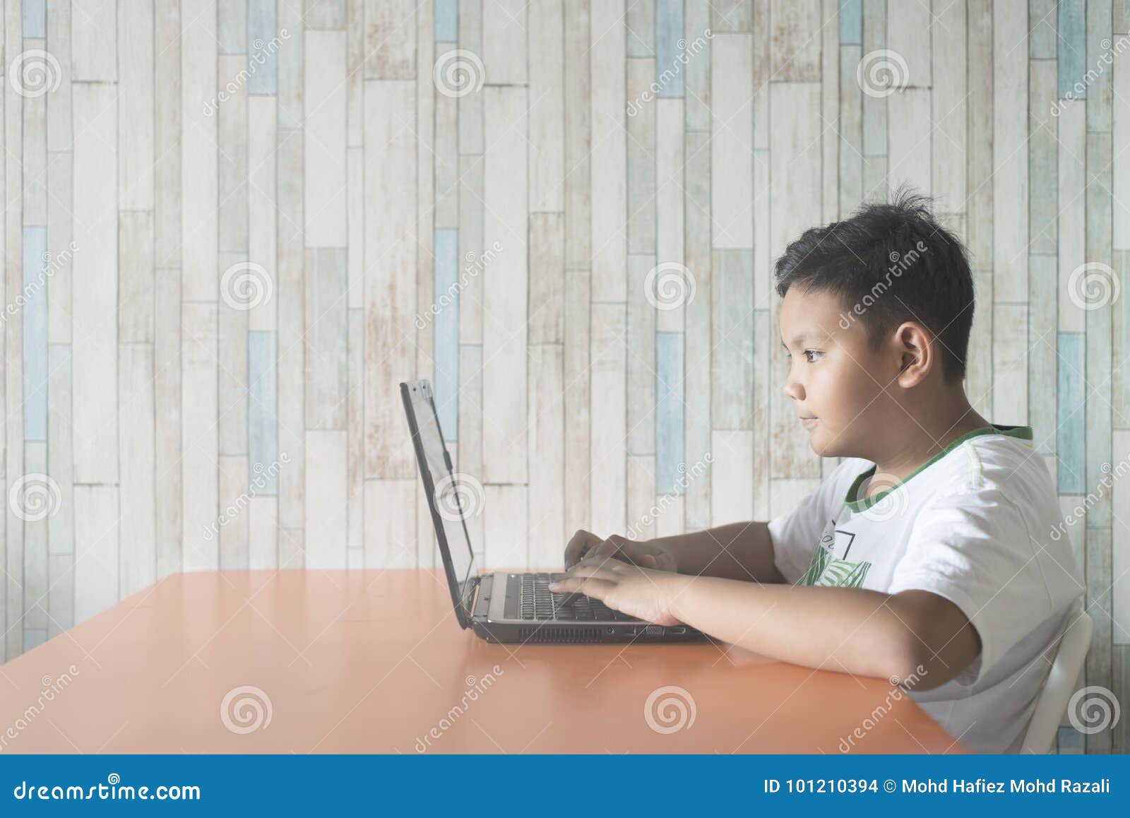 Young Asian Boy Using Laptop Computer at Dining Table at Home. Stock ...