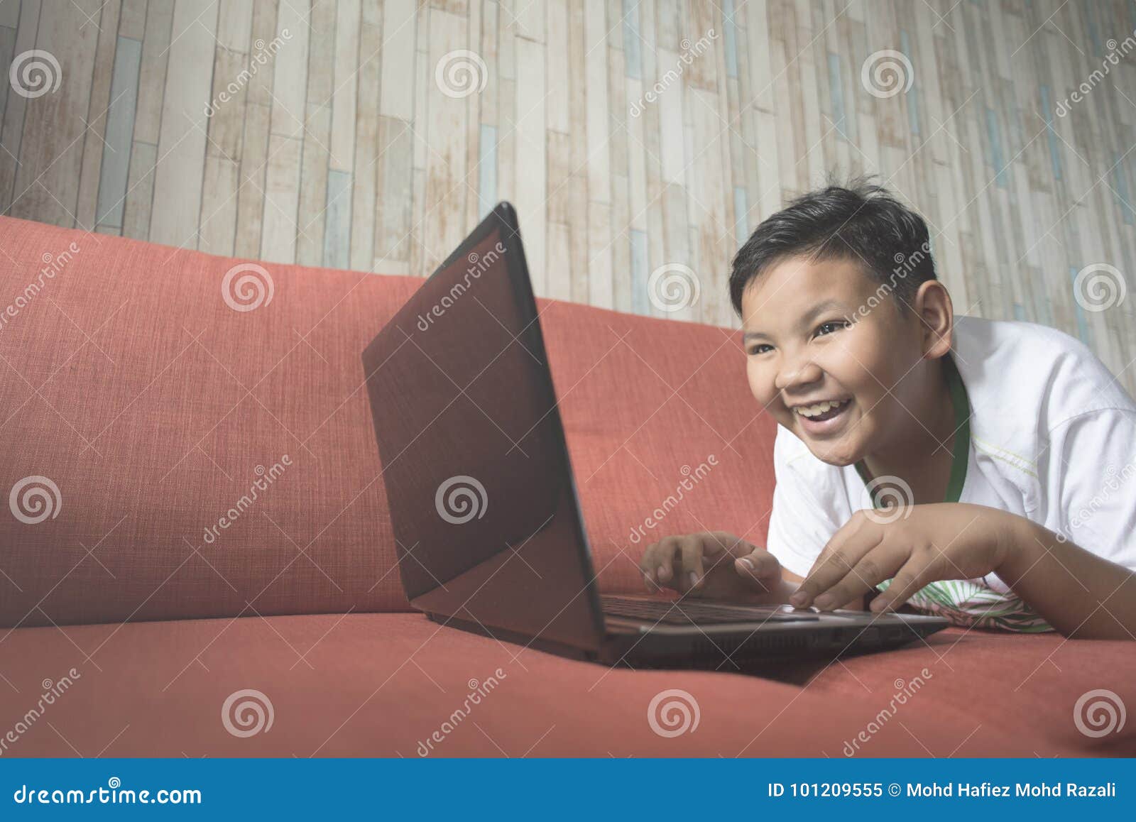 Young Asian Boy Using Laptop Computer on a Sofa at Home. Stock Image ...