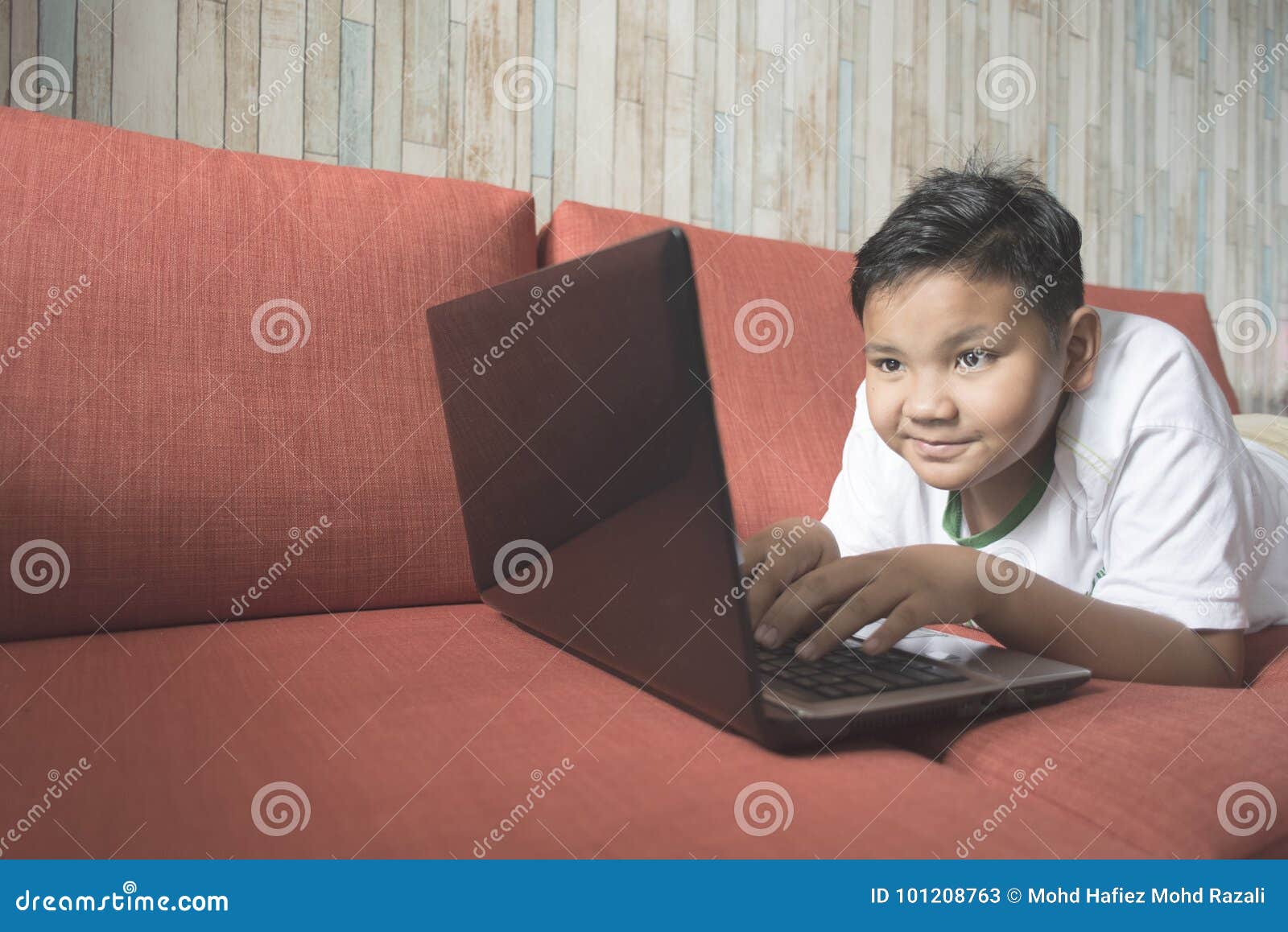 Young Asian Boy Using Laptop Computer on a Sofa at Home. Stock Image ...