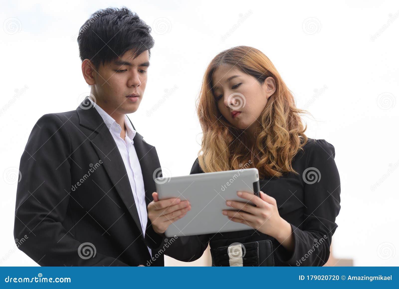 Young Asian Business Couple Using Digital Tablet Together in the City ... Young Asian Business Couple Using Digital Tablet Together in the City ...