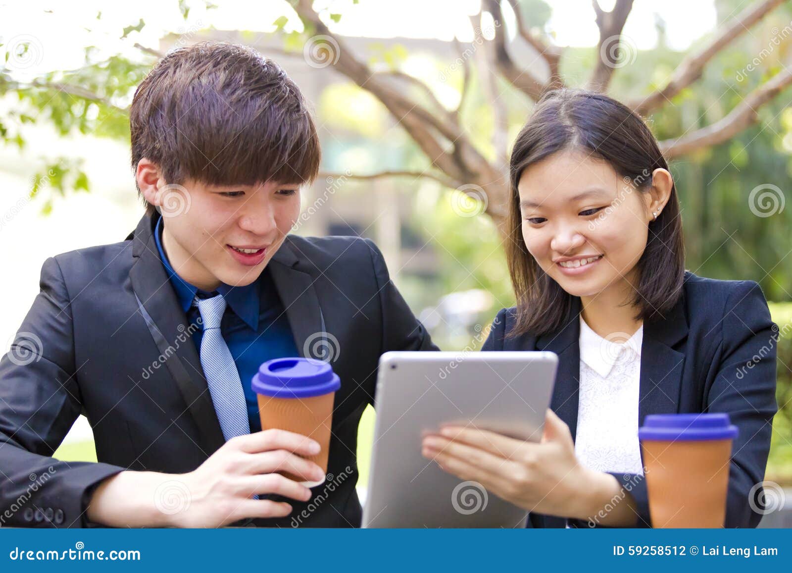 Young Asian Business Executives in Discussion Using Table PC Stock ...
