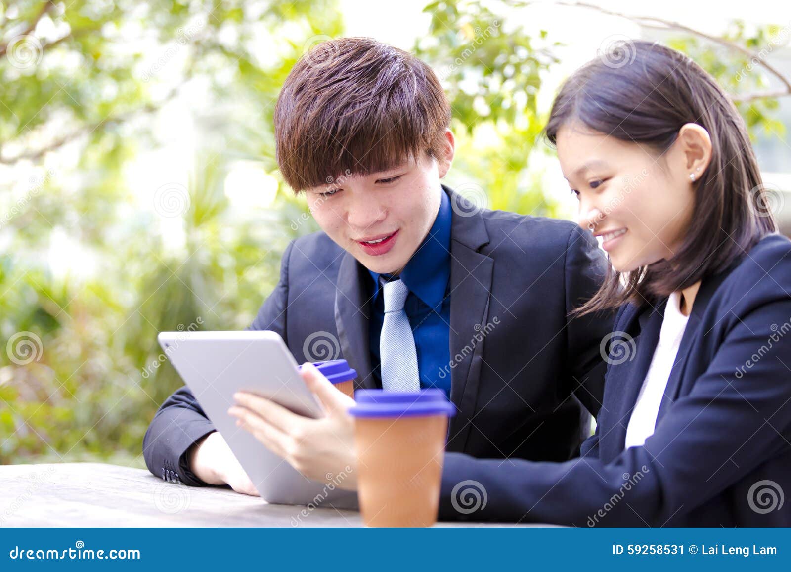 Young Asian Business Executives in Discussion Using Table PC Stock ...