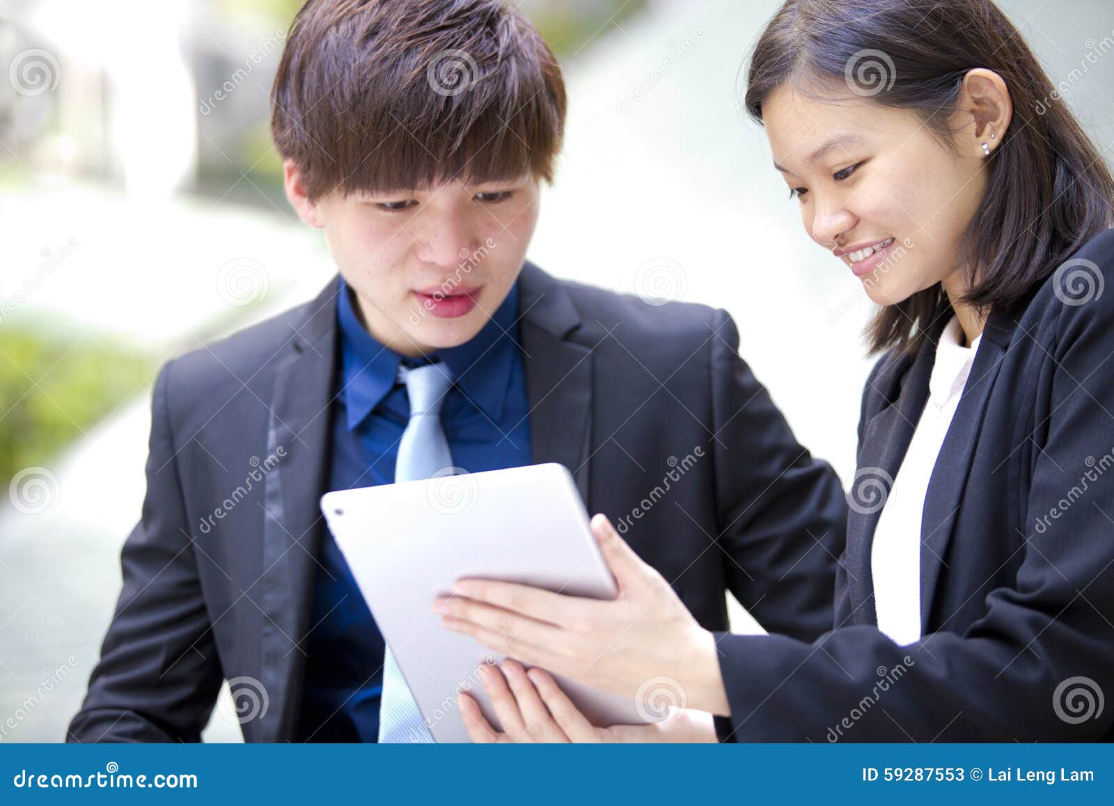 Young Asian Business Executives Walking and Discussing Using Tablet PC ...