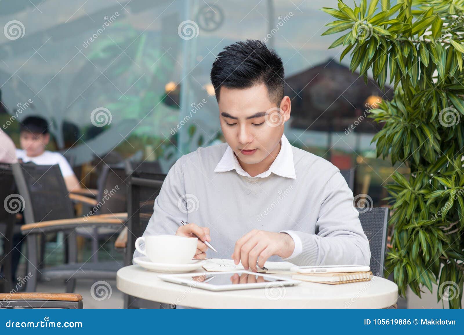 Young Asian Businessman Working with Documents at Cafe. Stock Photo ... Young Asian Businessman Working with Documents at Cafe. Stock Photo ...