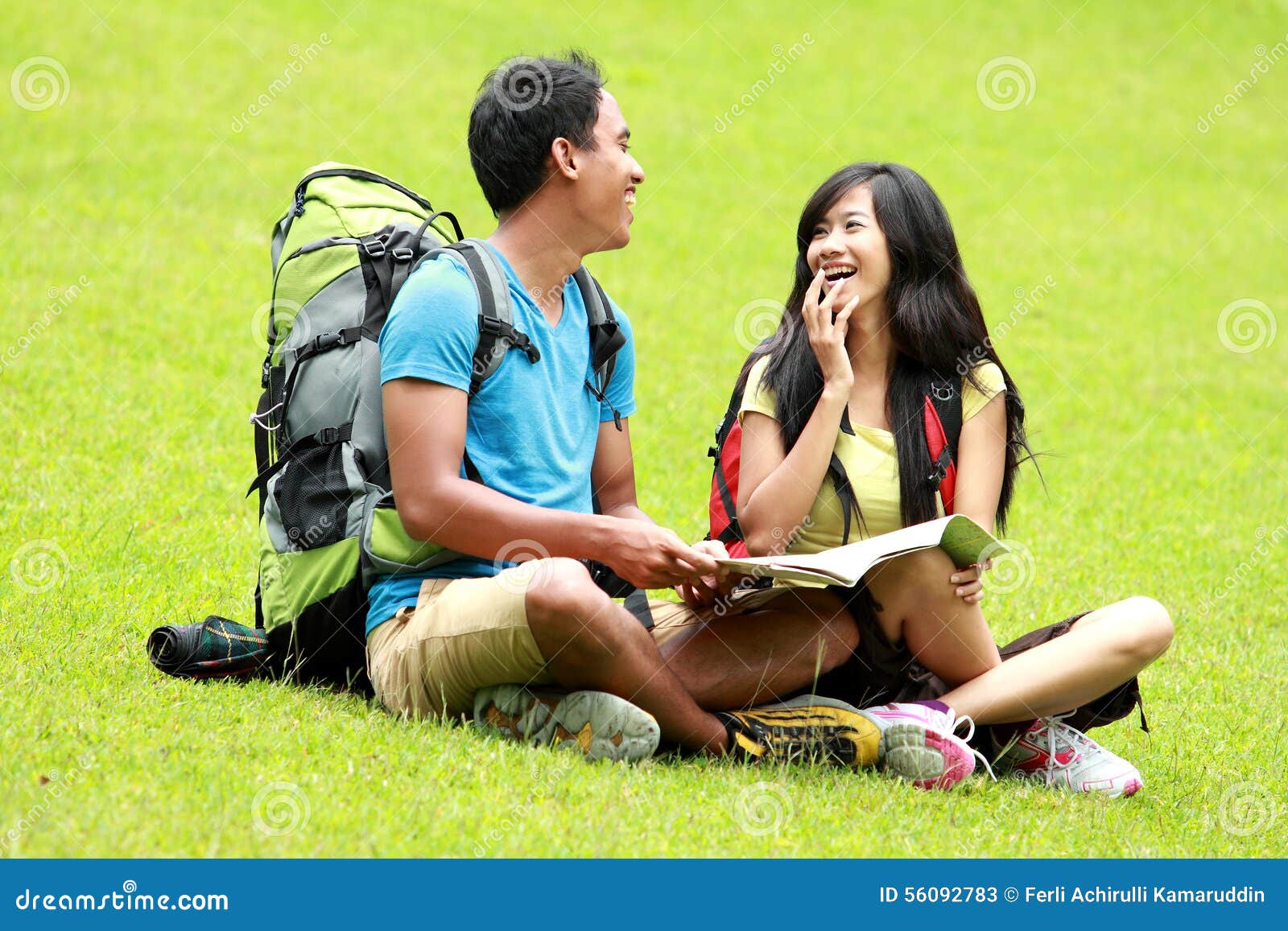 Young Asian Couple Chatting And Sitting On The Grass Stock Image