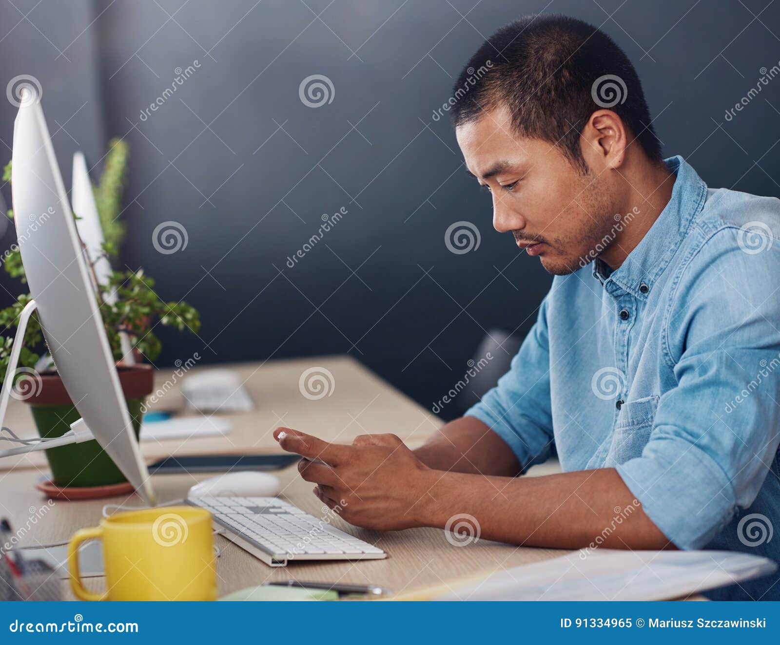 Young Asian Designer Sitting at Work Using a Cellphone Stock Image ...