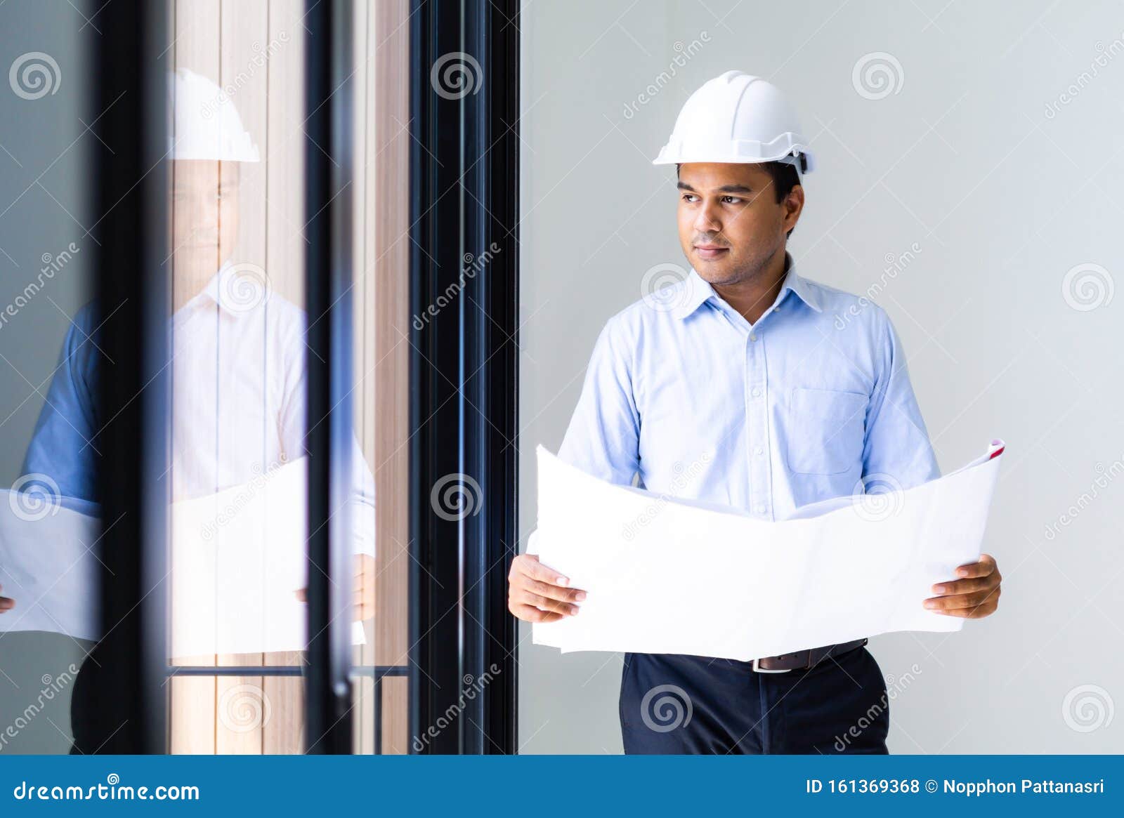 Young Asian Engineer or Architects Holding Layout Plan of Building ...