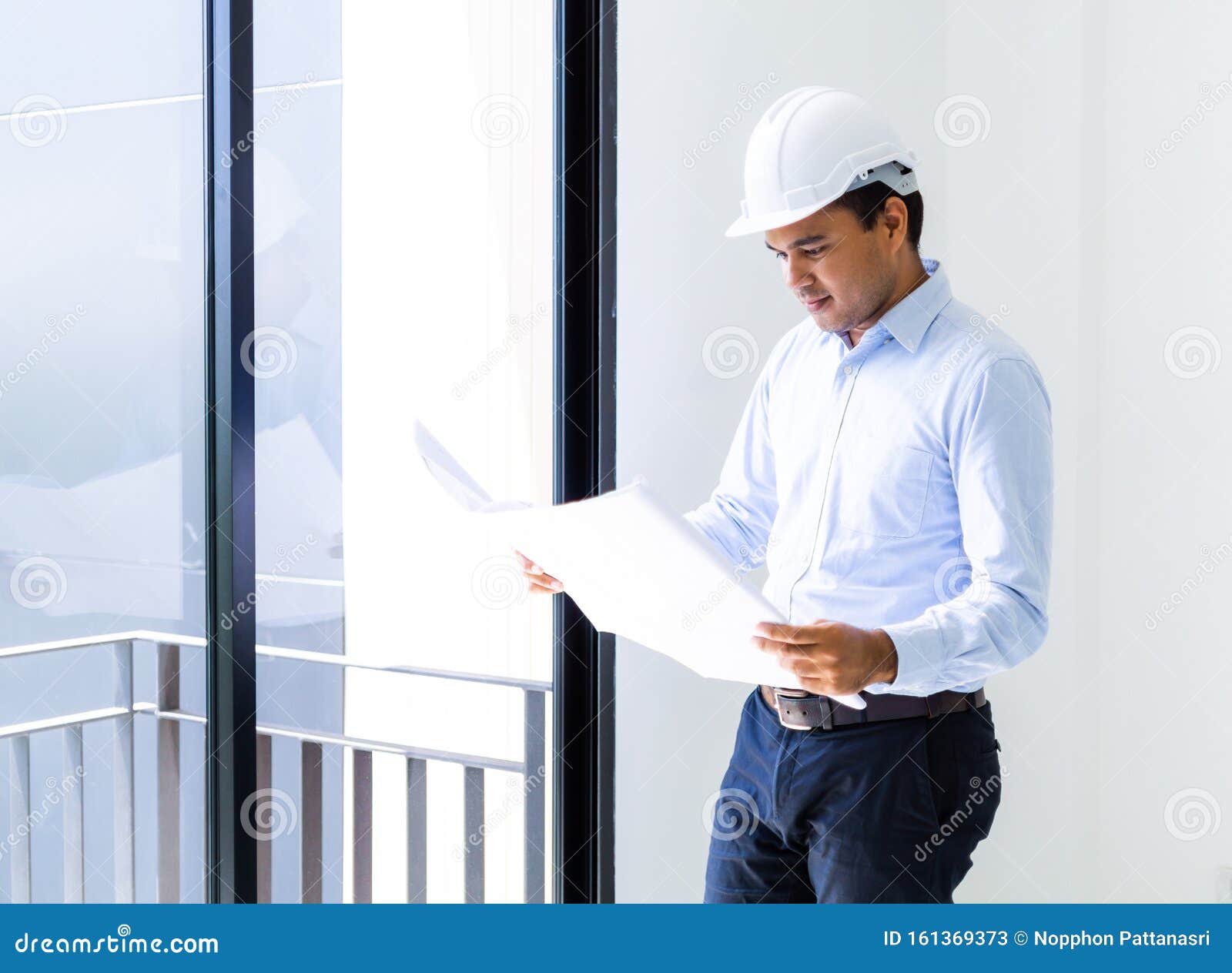 Young Asian Engineer or Architects Holding Layout Plan of Building ...