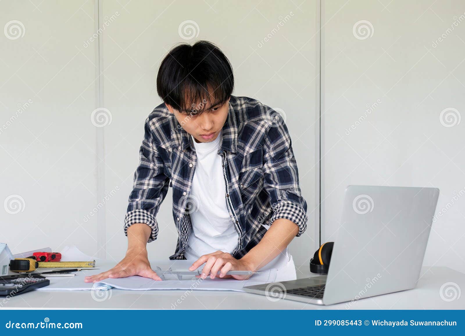 Young Asian Engineer Drawing Construction Project Plans on Plan Paper ...