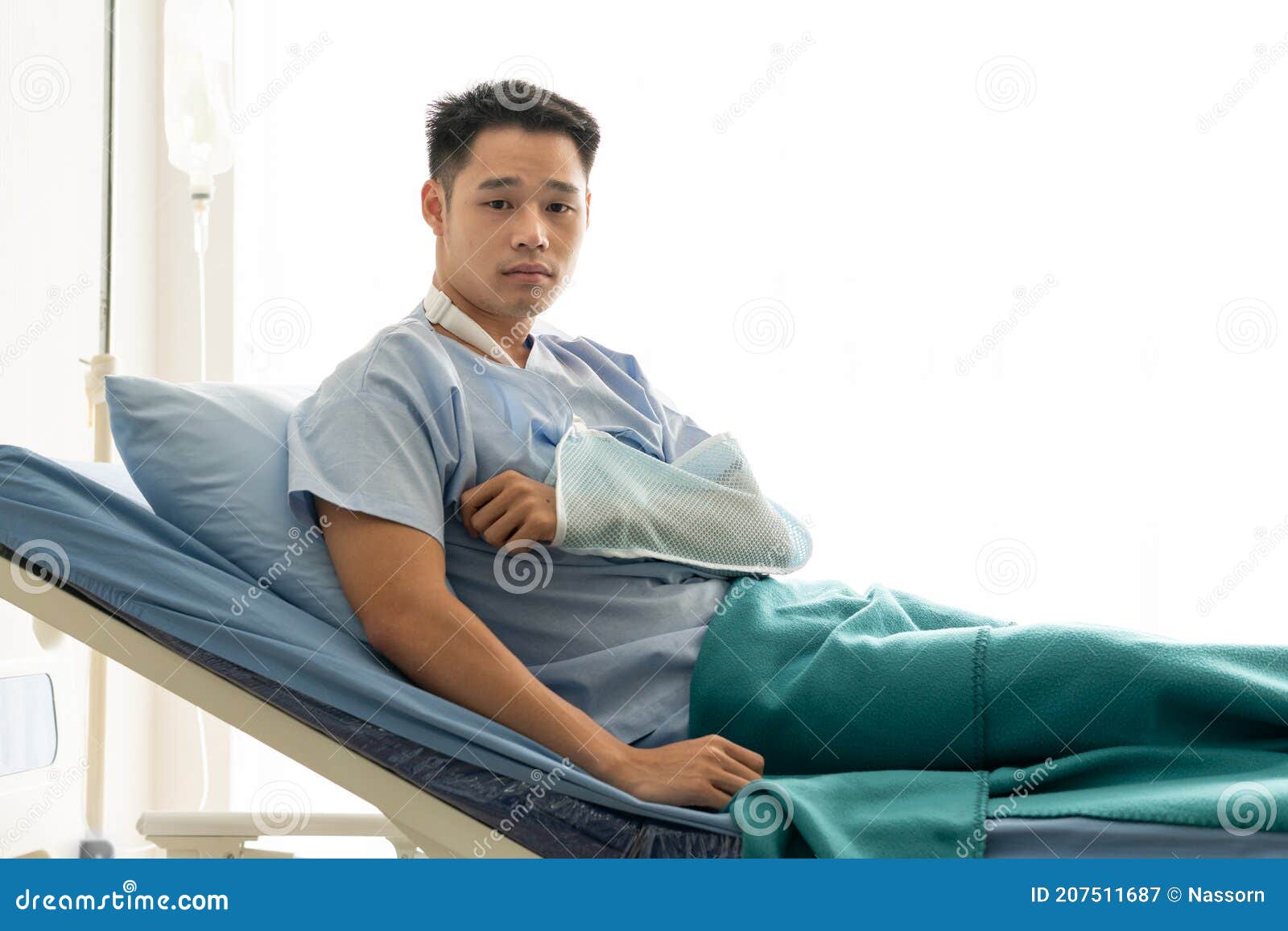 Young Asian Man with Arm in Sling Lying on Hospital Bed. Broken Arm ... Young Asian Man with Arm in Sling Lying on Hospital Bed. Broken Arm ...
