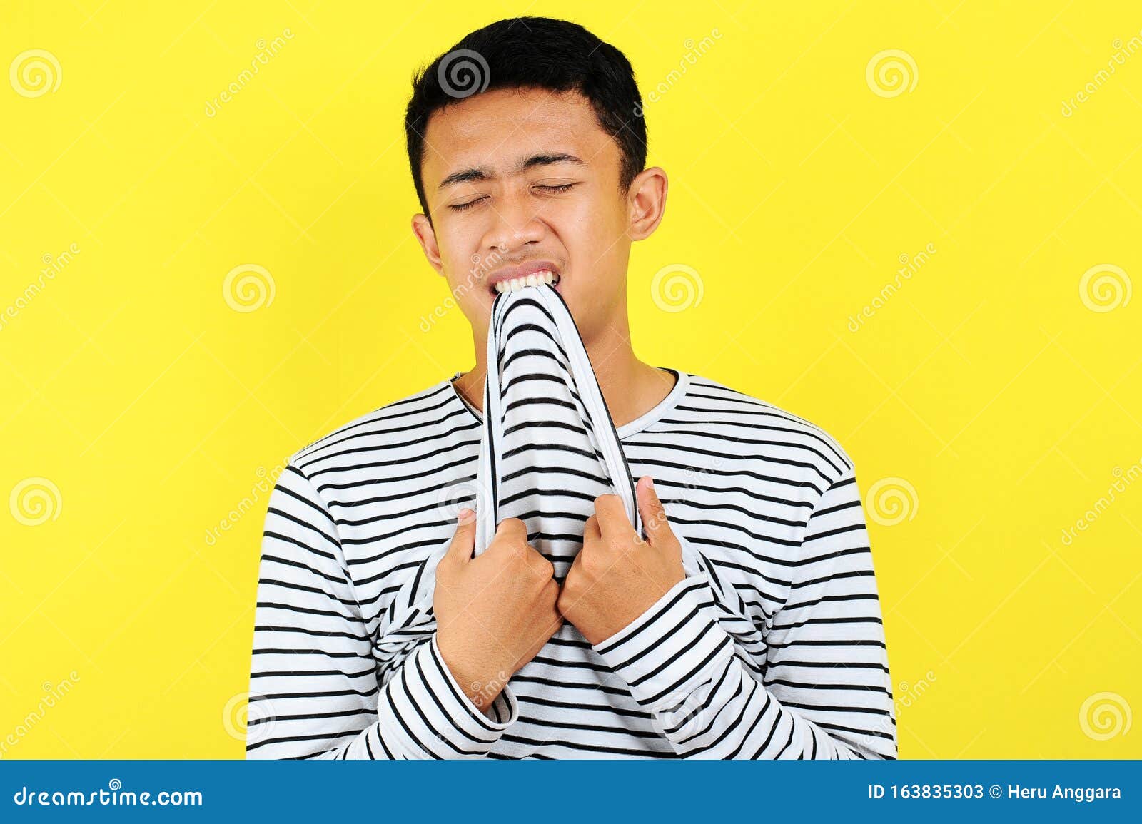Young Asian Man Biting Clothes, on Yellow Stock Image - Image of ...