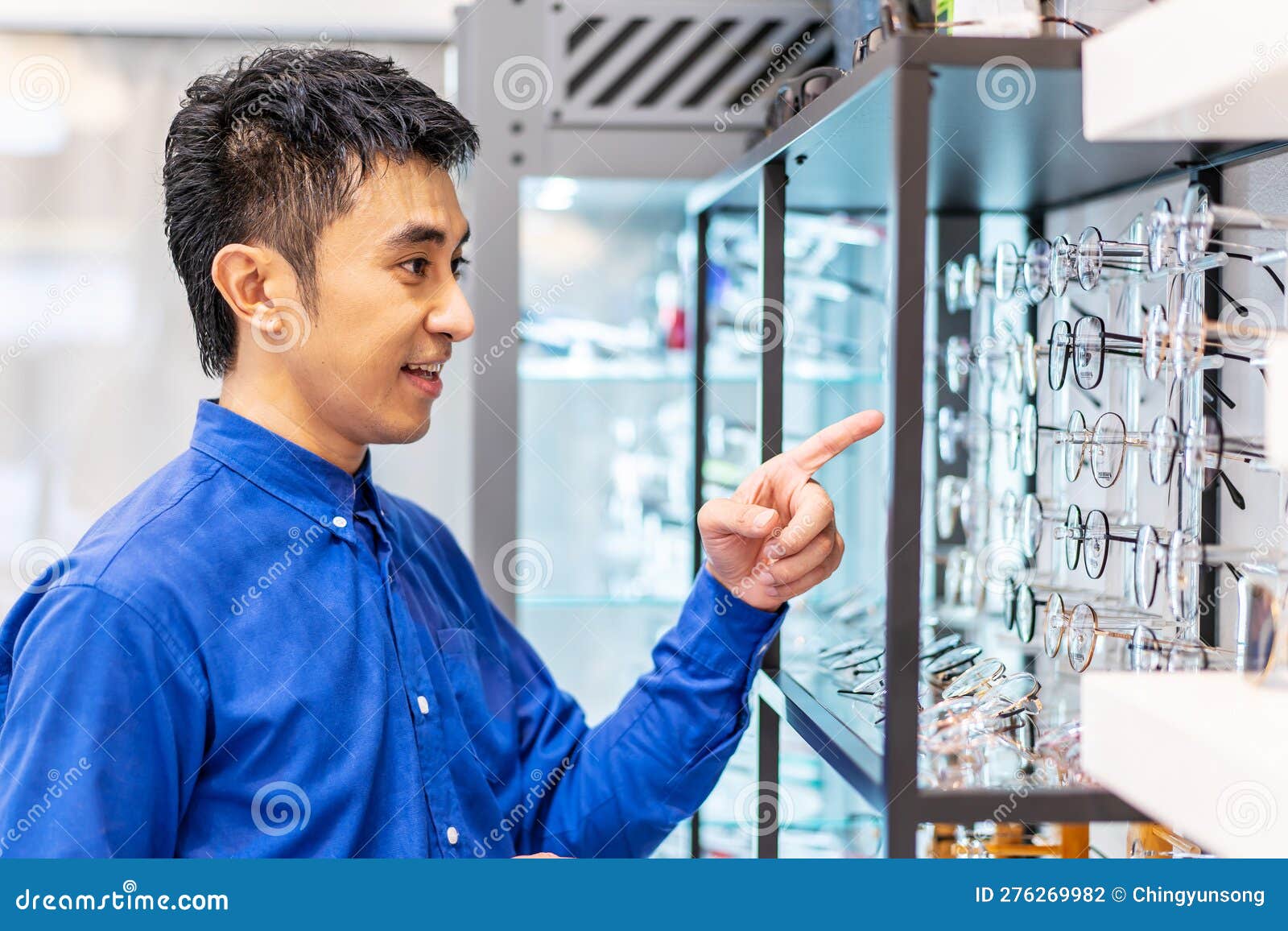 Young Asian Man Taking Glasses From The Shelf To Try Them On Glasses Shop Ophthalmology Clinic
