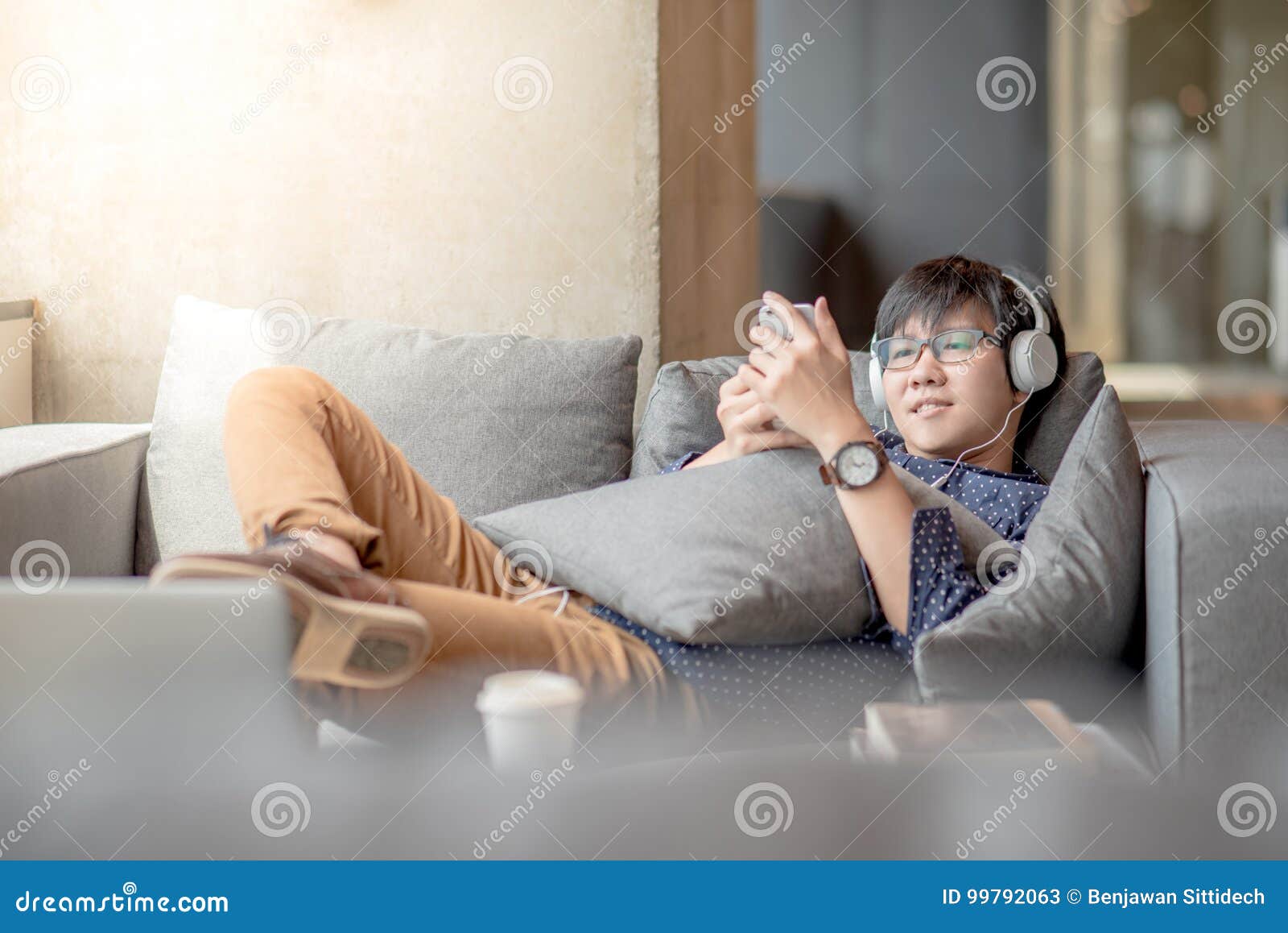 Young Asian Man Using Smartphone Relaxing on Sofa Stock Image - Image ...