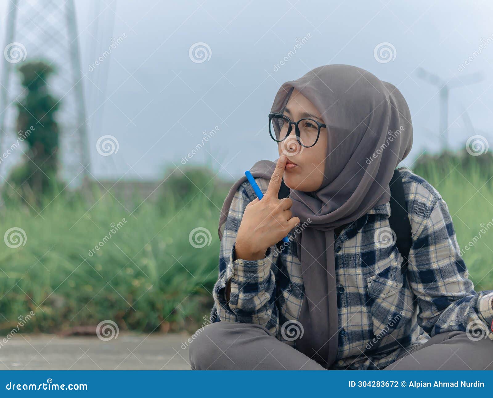 Young Asian Woman Sitting on the Ground in the Park and Thinking ...