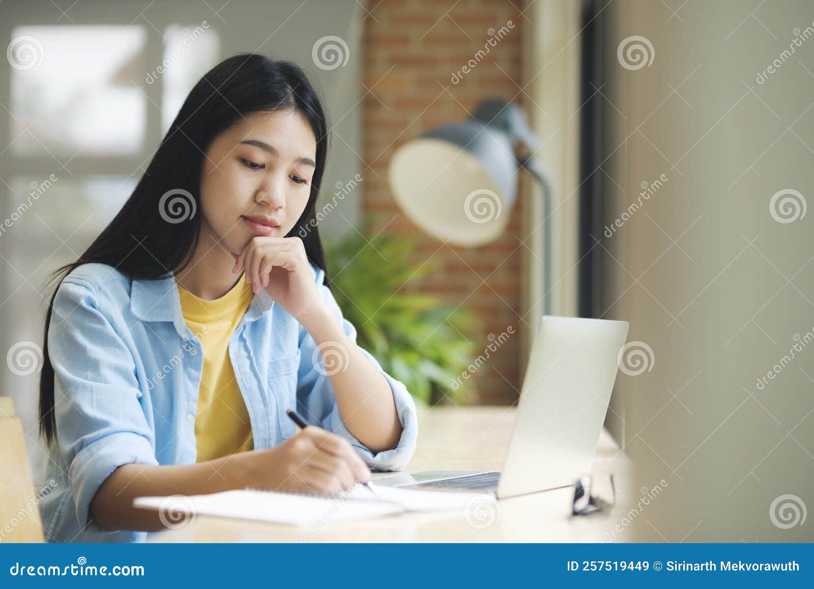 Young Asian Woman Sitting at Table Studying and Writing on Notebook ...