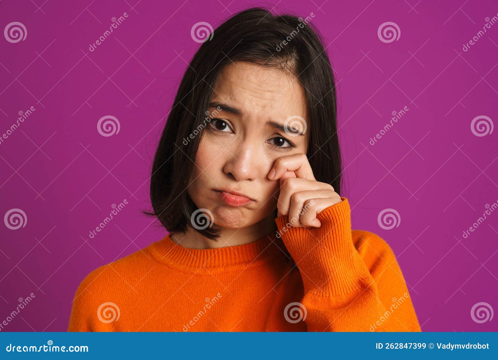 Young Asian Woman Wearing Sweater Crying While Wiping Her Tears Stock