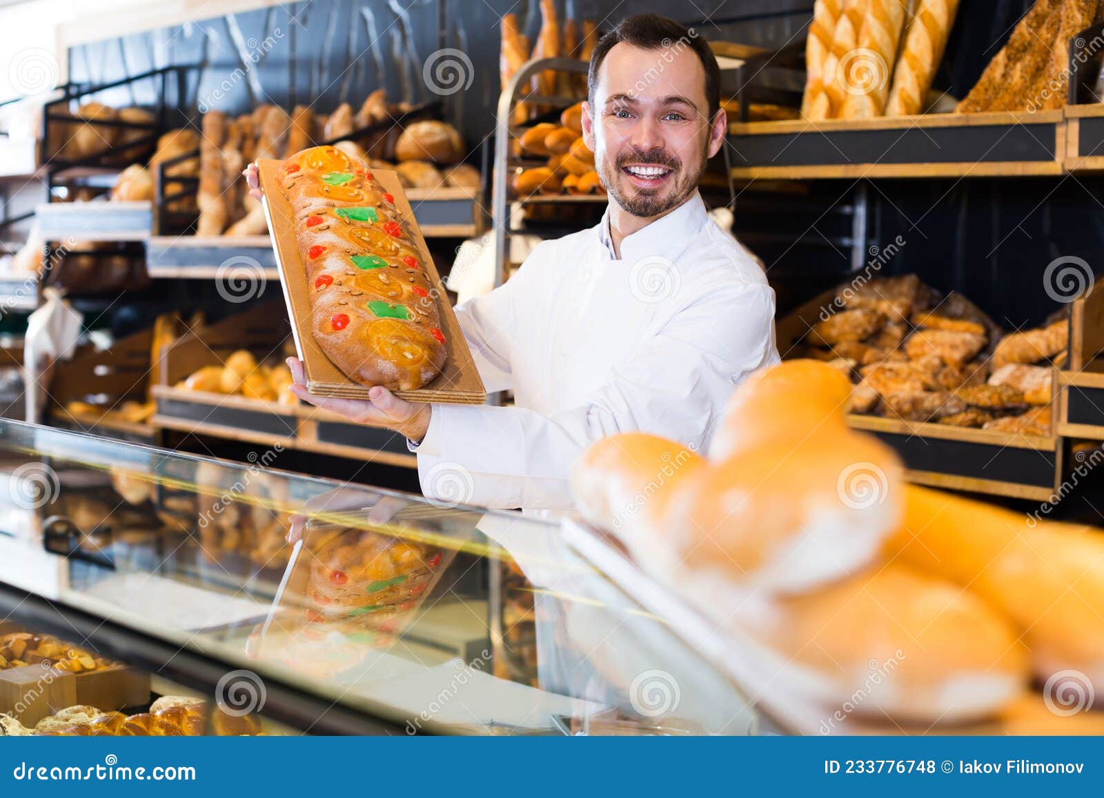 Young Assistant Demonstrating Festive Cake in Bakery Stock Photo ...