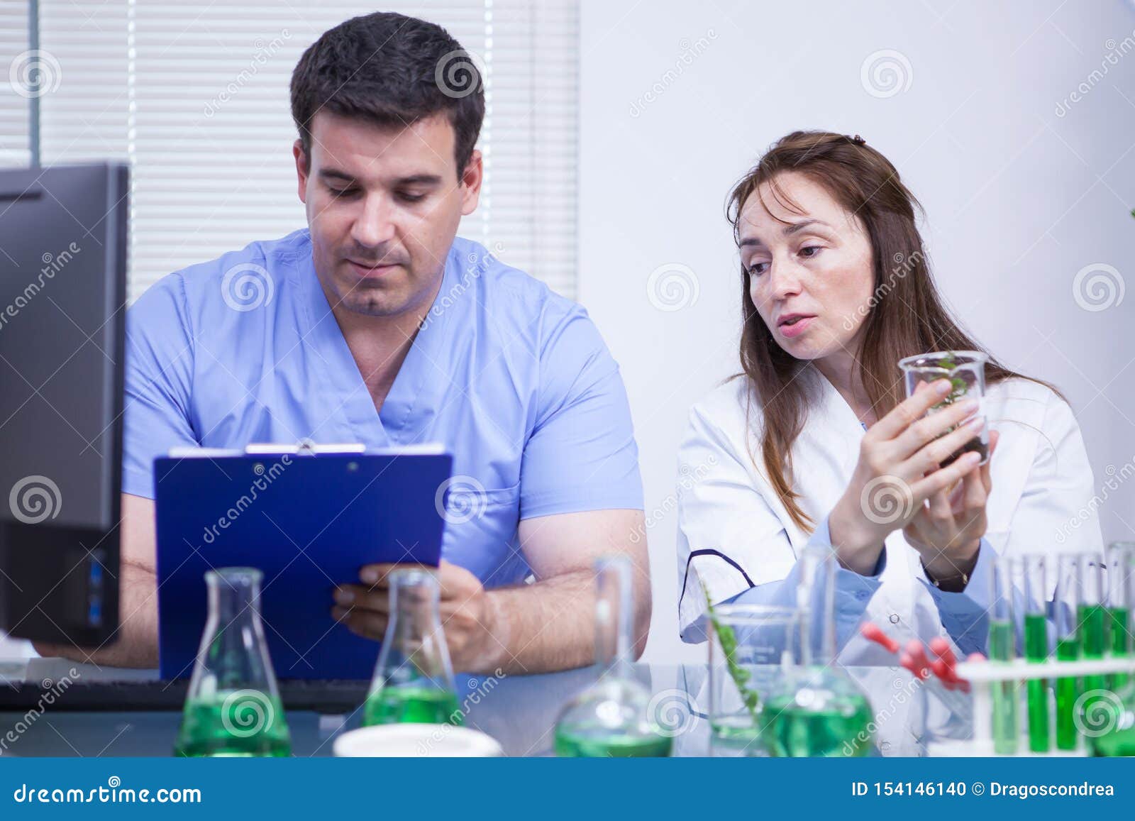 Young Assistant Writing Notes on His Notepad in a Research Lab Stock ...