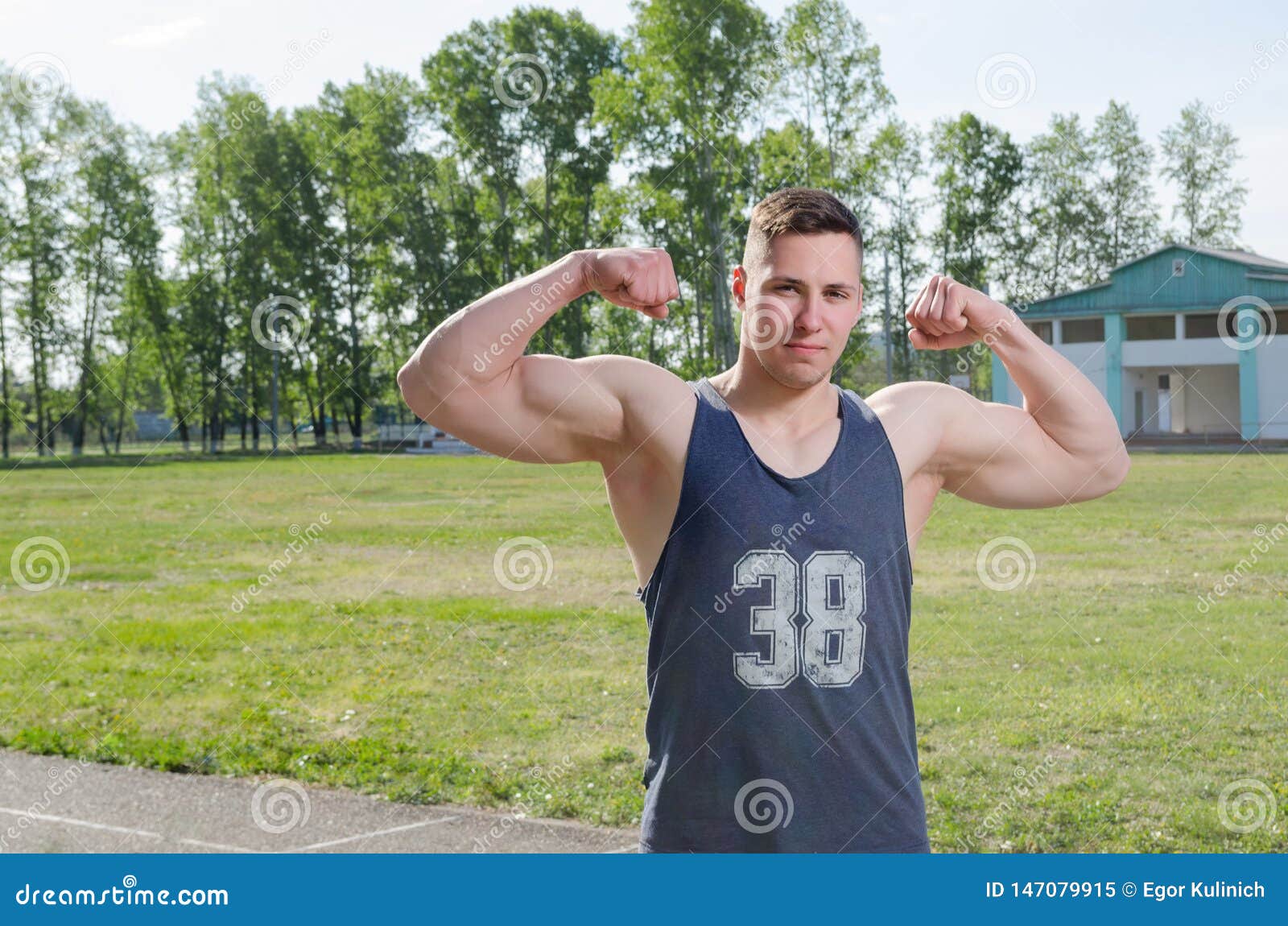 Young athlete shows biceps stock image. Image of motion - 147079915