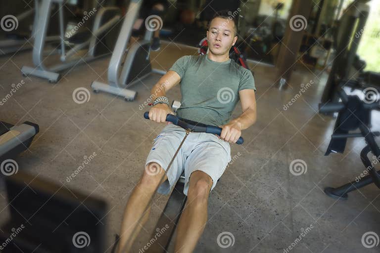 Young Athletic and Attractive Man Training Body Building Doing Rowing ...