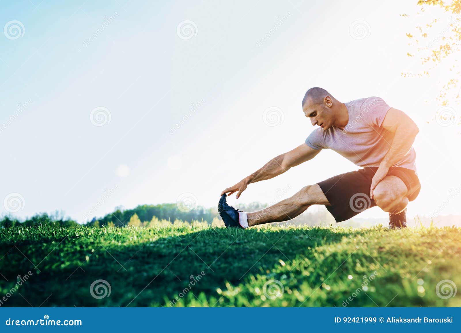 Young Athletic Runner Doing Stretching Exercise, Preparing for Workout ...