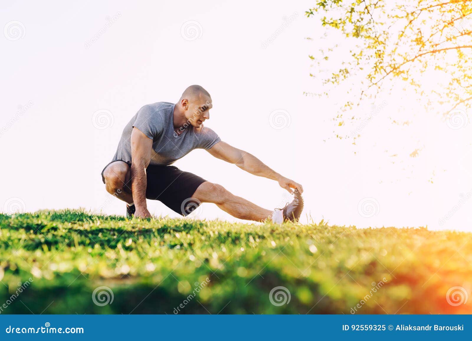Young Athletic Runner Doing Stretching Exercise, Preparing for Workout ...