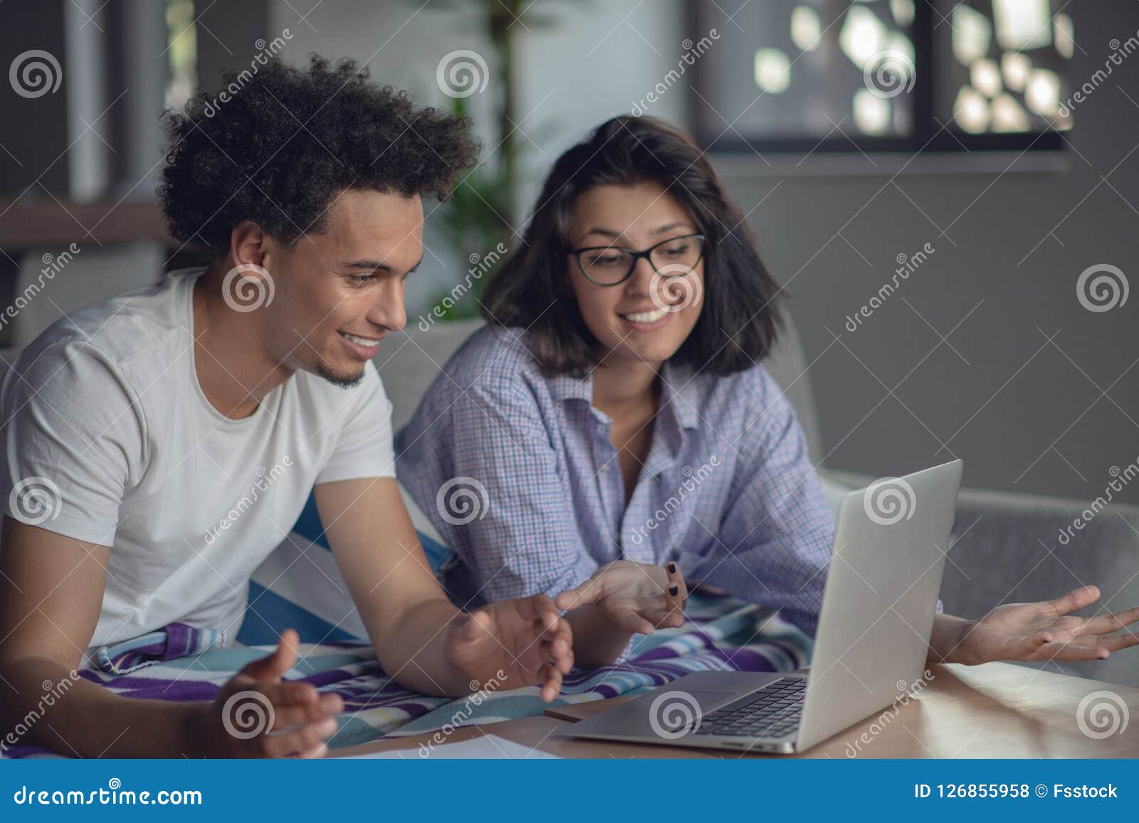 Young Attractive Diverse Couple Browsing Internet, Using Laptop ...