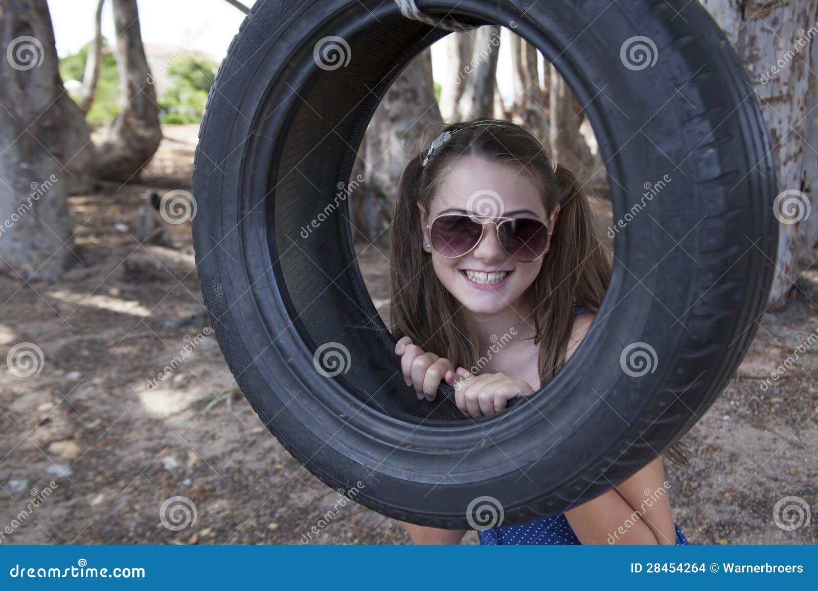 A Young Attractive Girl Playing with a Tyre Swing Stock Photo - Image ...